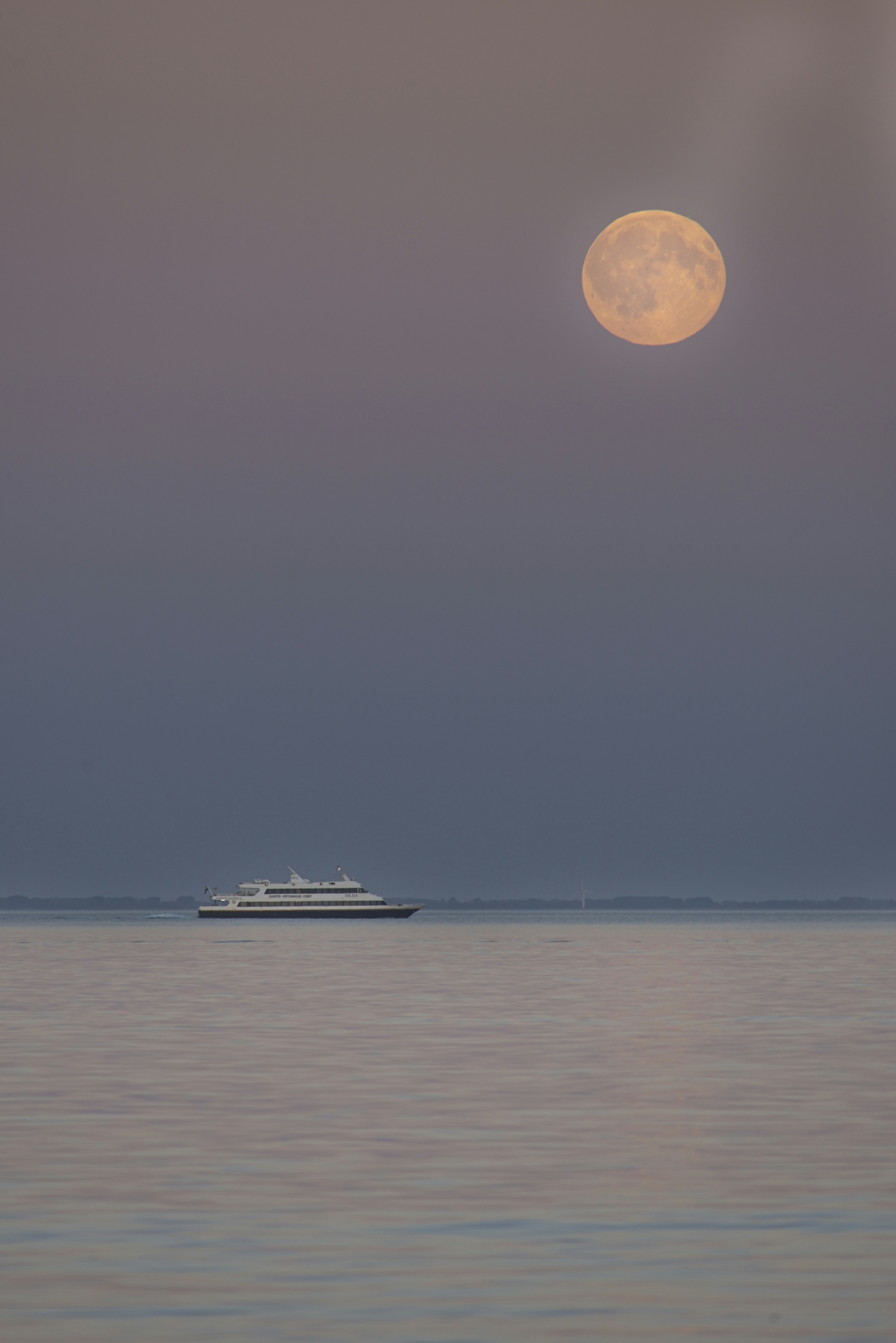 Moonrise over a Quiet Harbor: A Vessel Beneath the Pale Sky
