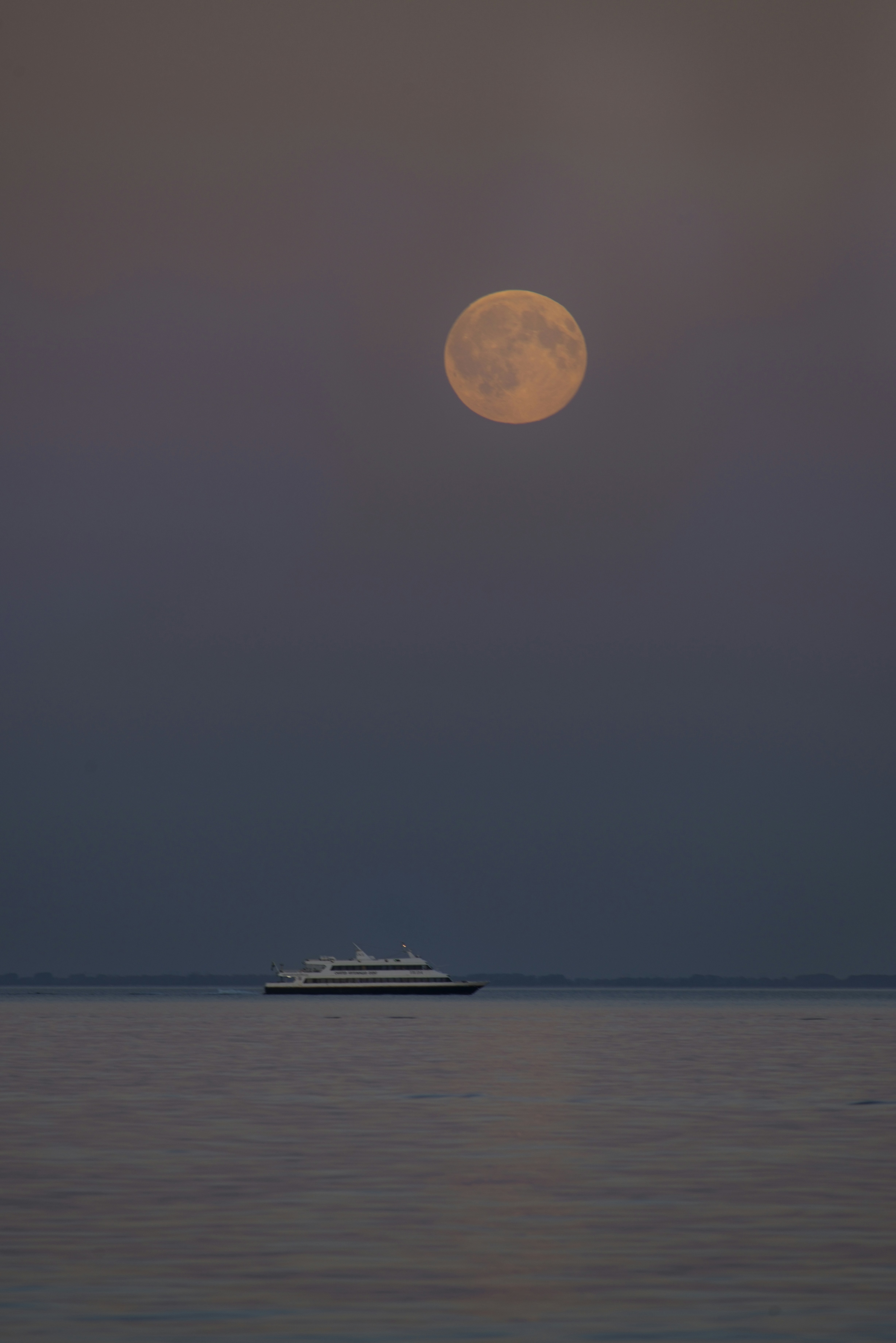 Moonrise over Quiet Waters: a lone yacht under twilight