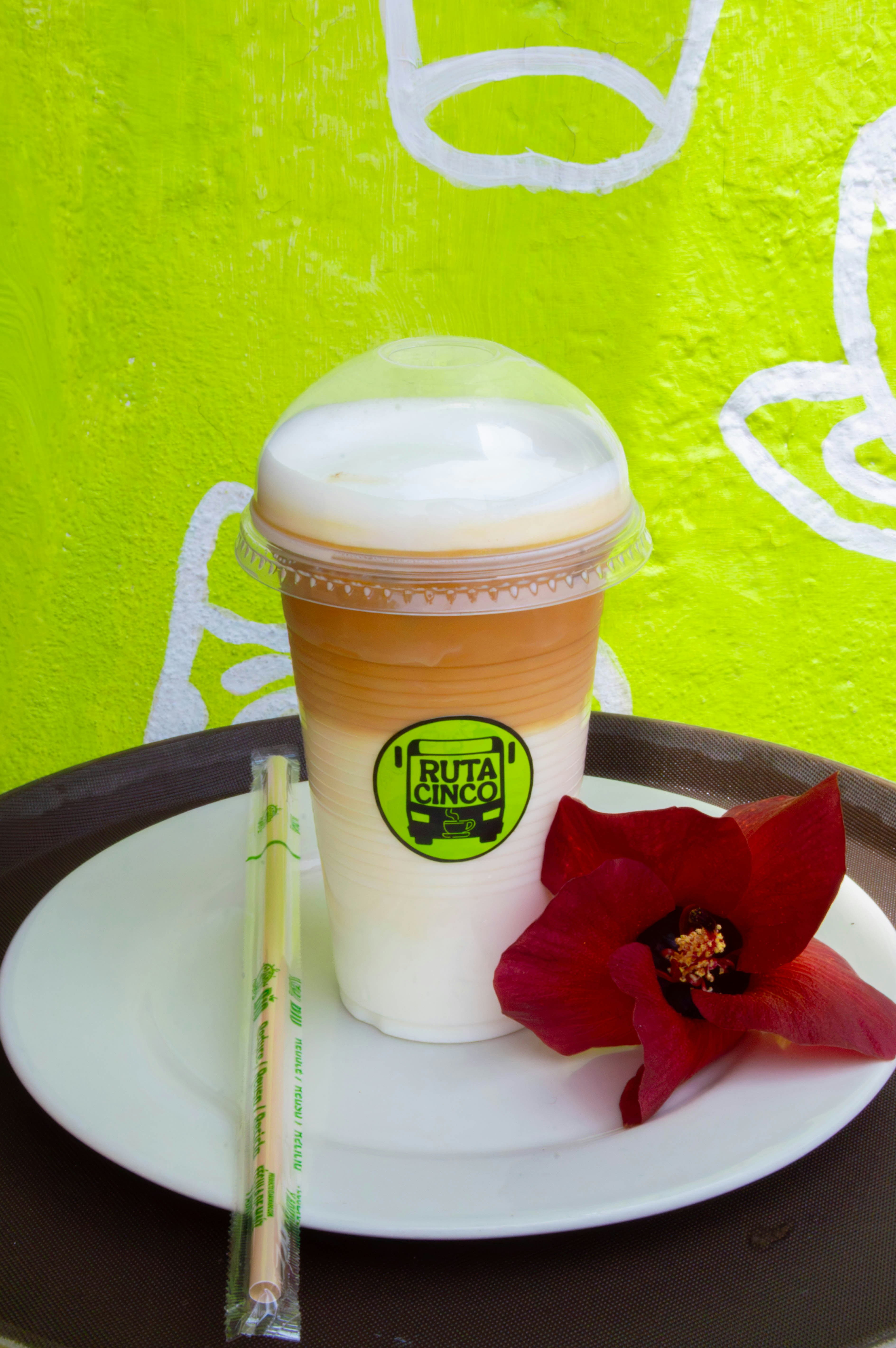 Bright Green Graffiti Café Latte with Red Hibiscus on White Plate