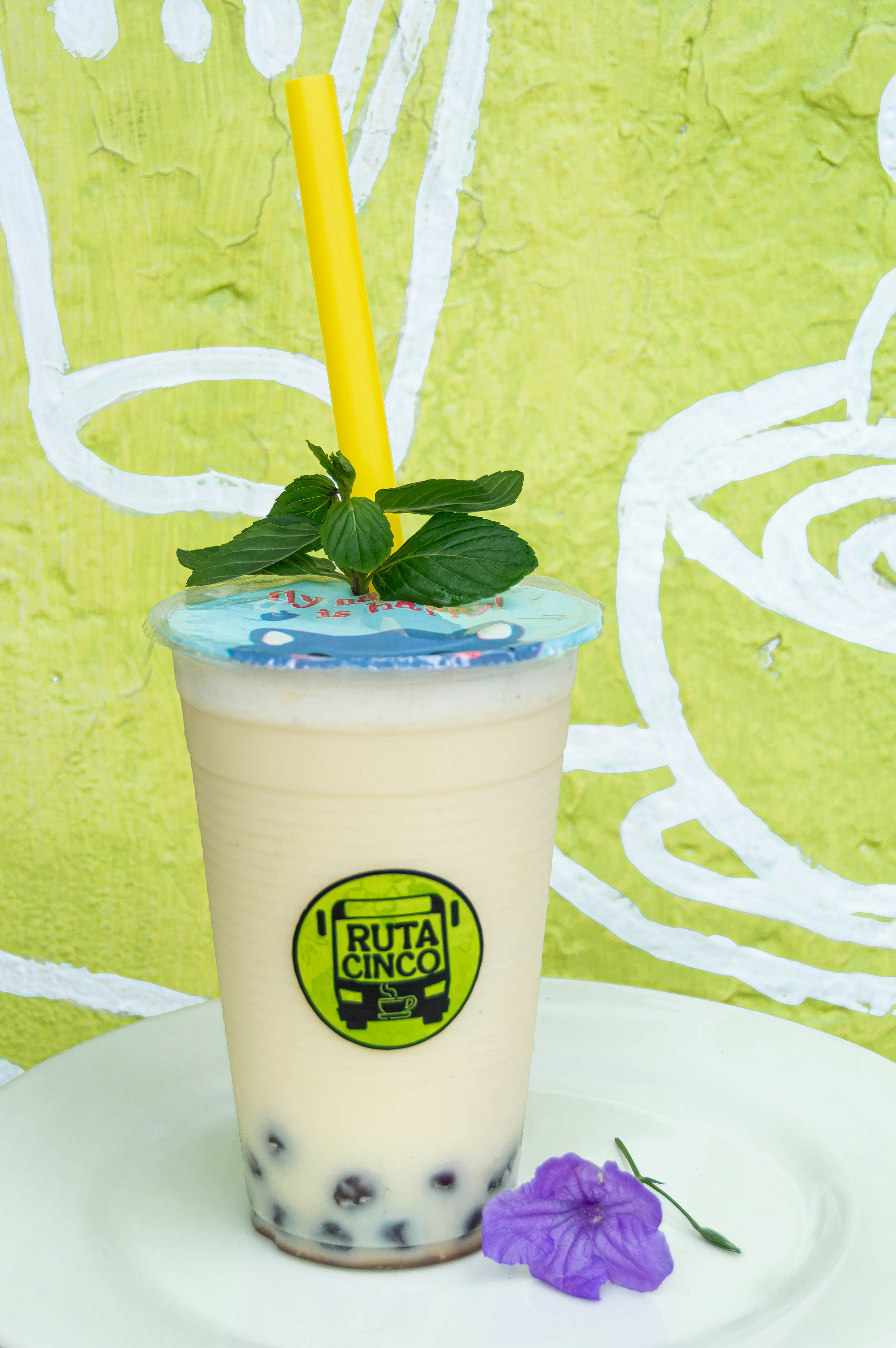 Mint-green backdrop meets creamy bubble tea: a sunny street-side treat