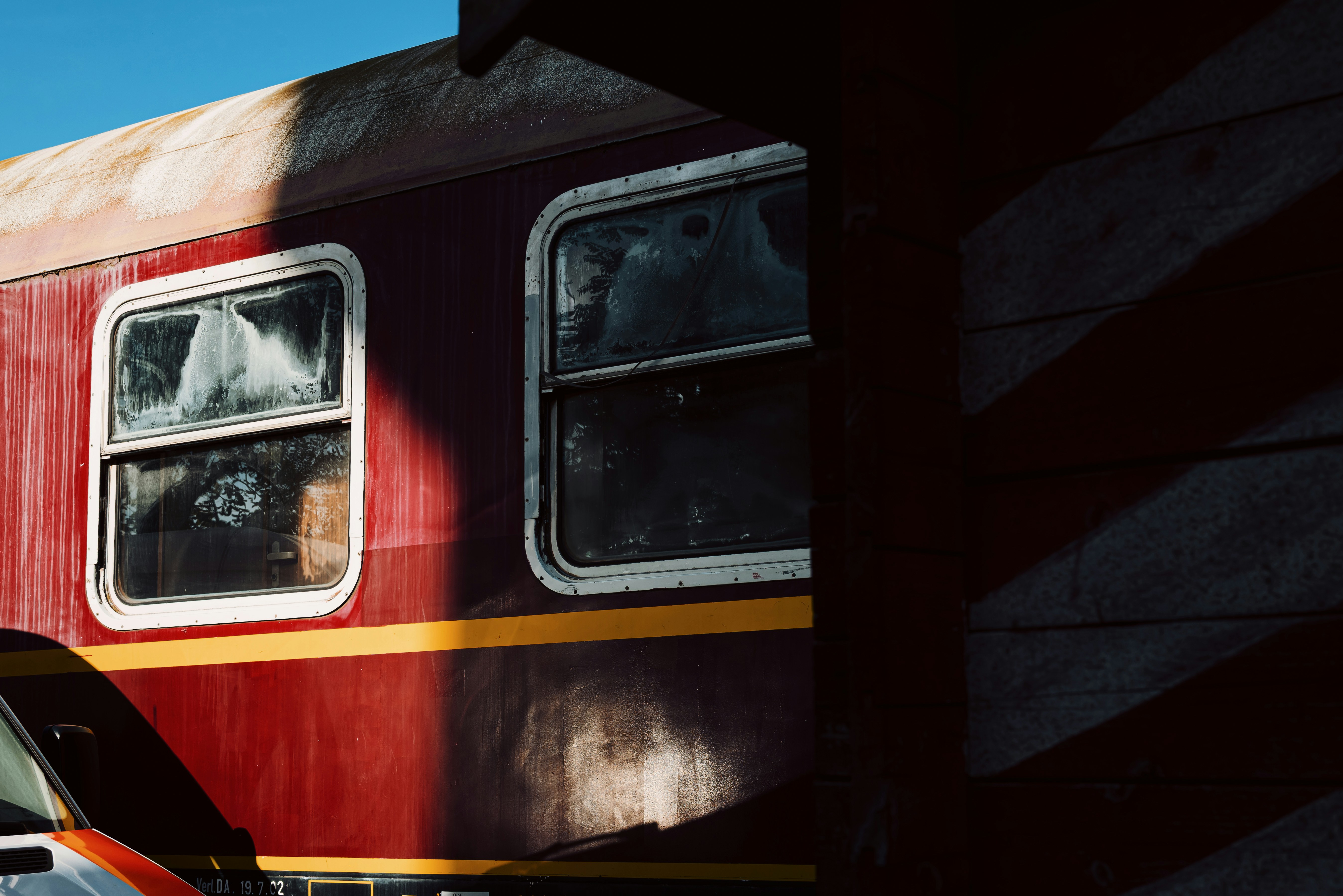 Red Rail Car in Shadow: A Glimpse of Daylight on a Vintage Carriage