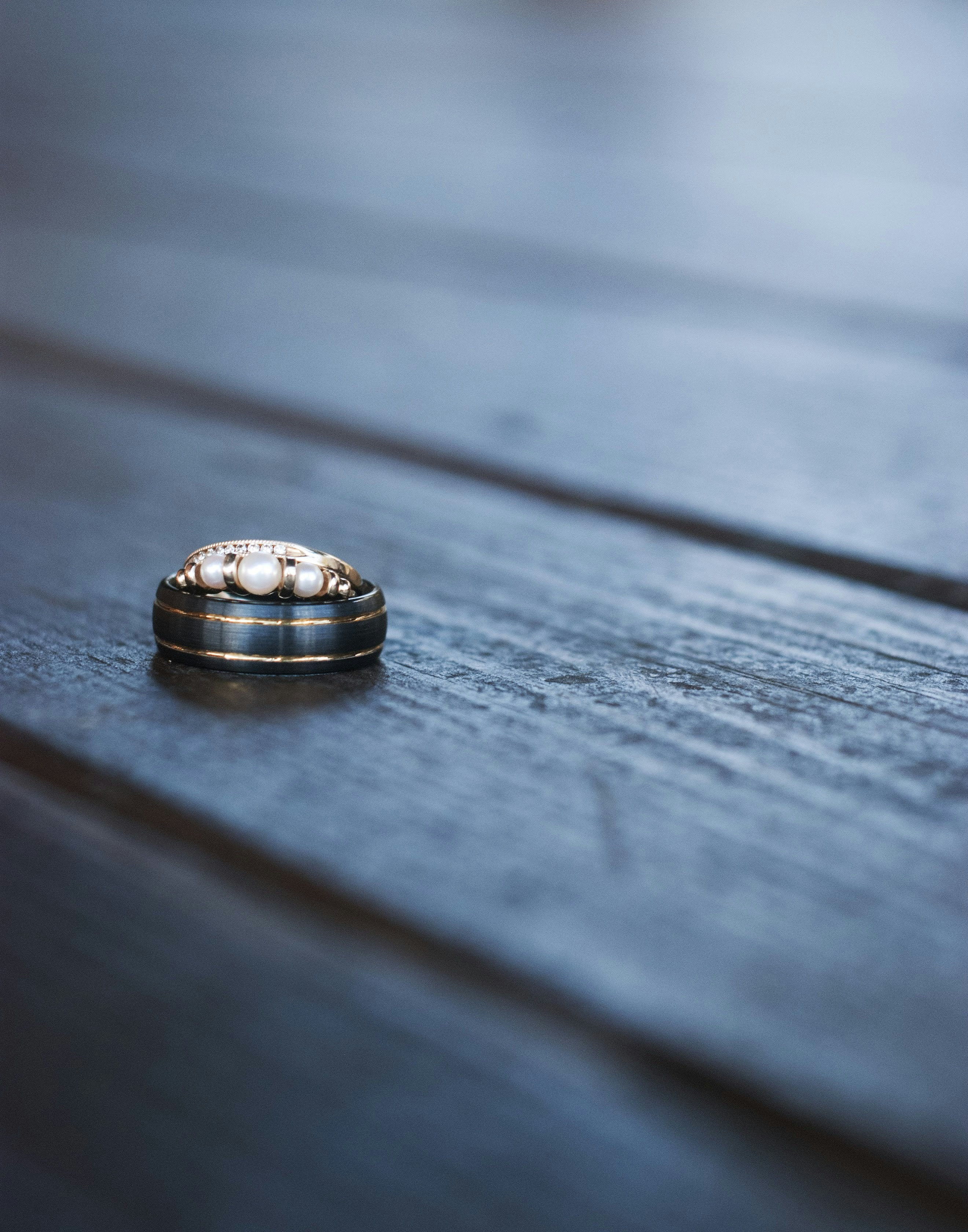 Pearl Duo: A Gentle Ring Resting on Weathered Wood