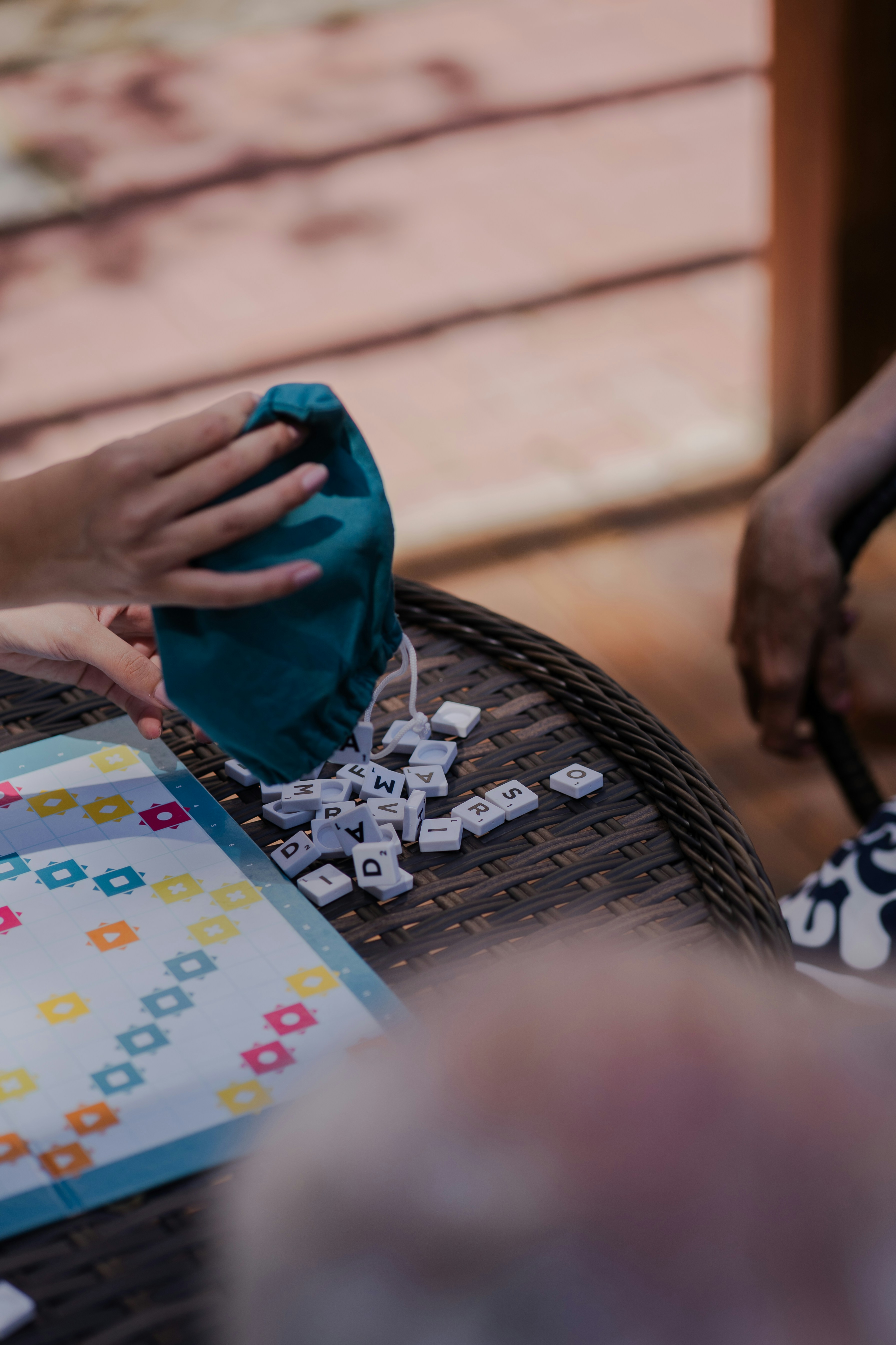 Hands Minding Letters: a tabletop moment with scattered tiles and a teal pouch