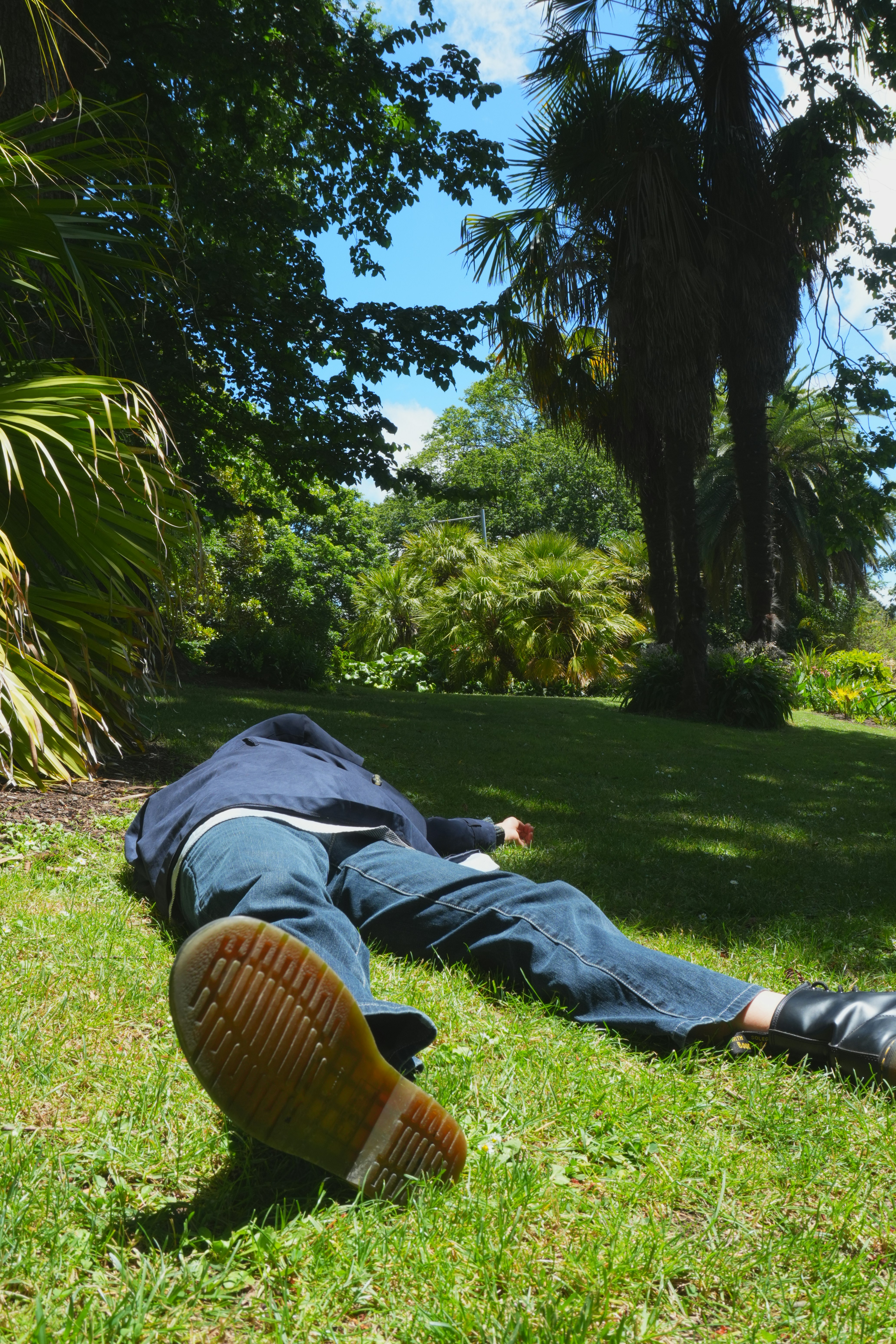 Lying in the Shade: a Park Scene with Shoes in the Foreground
