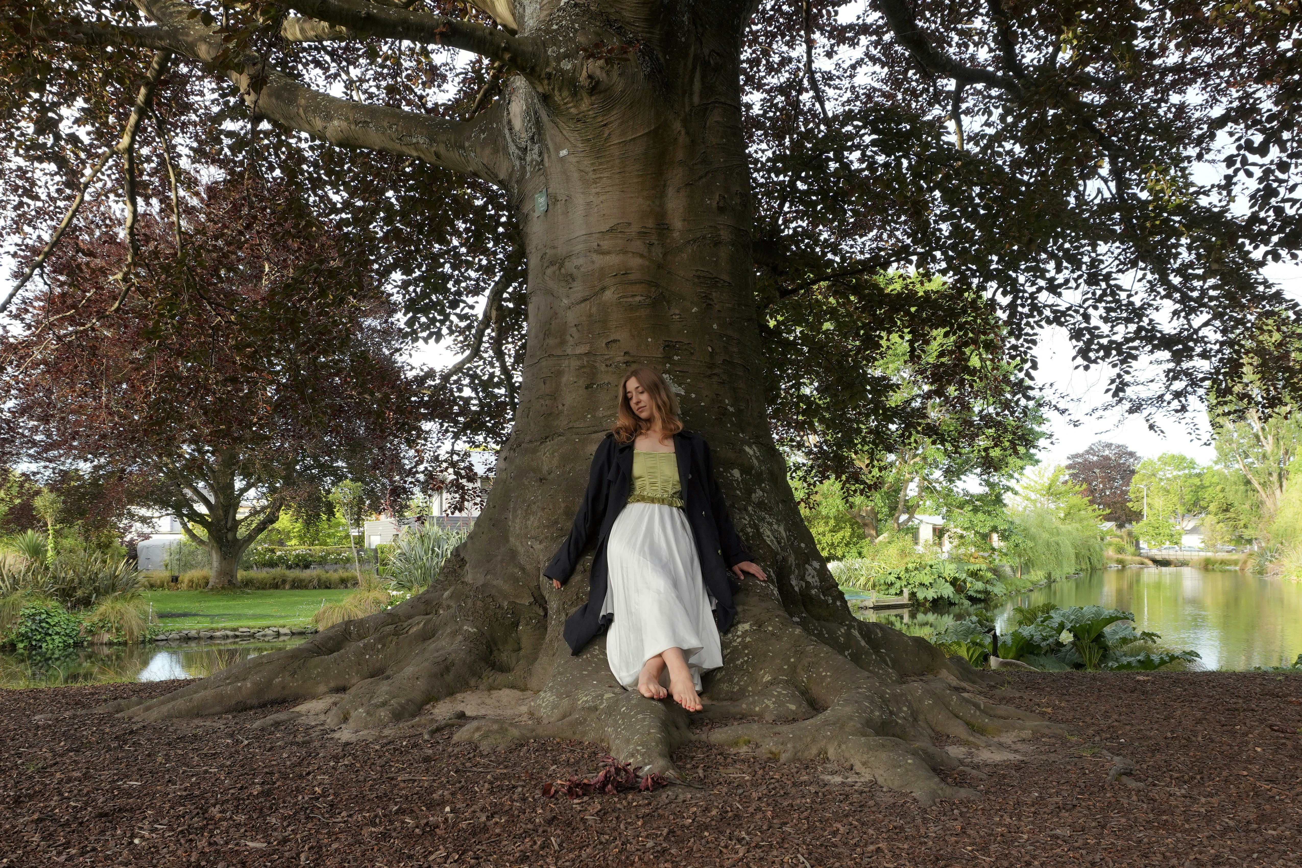 Rootbound Reverie: A Woman Beneath an Ancient Tree