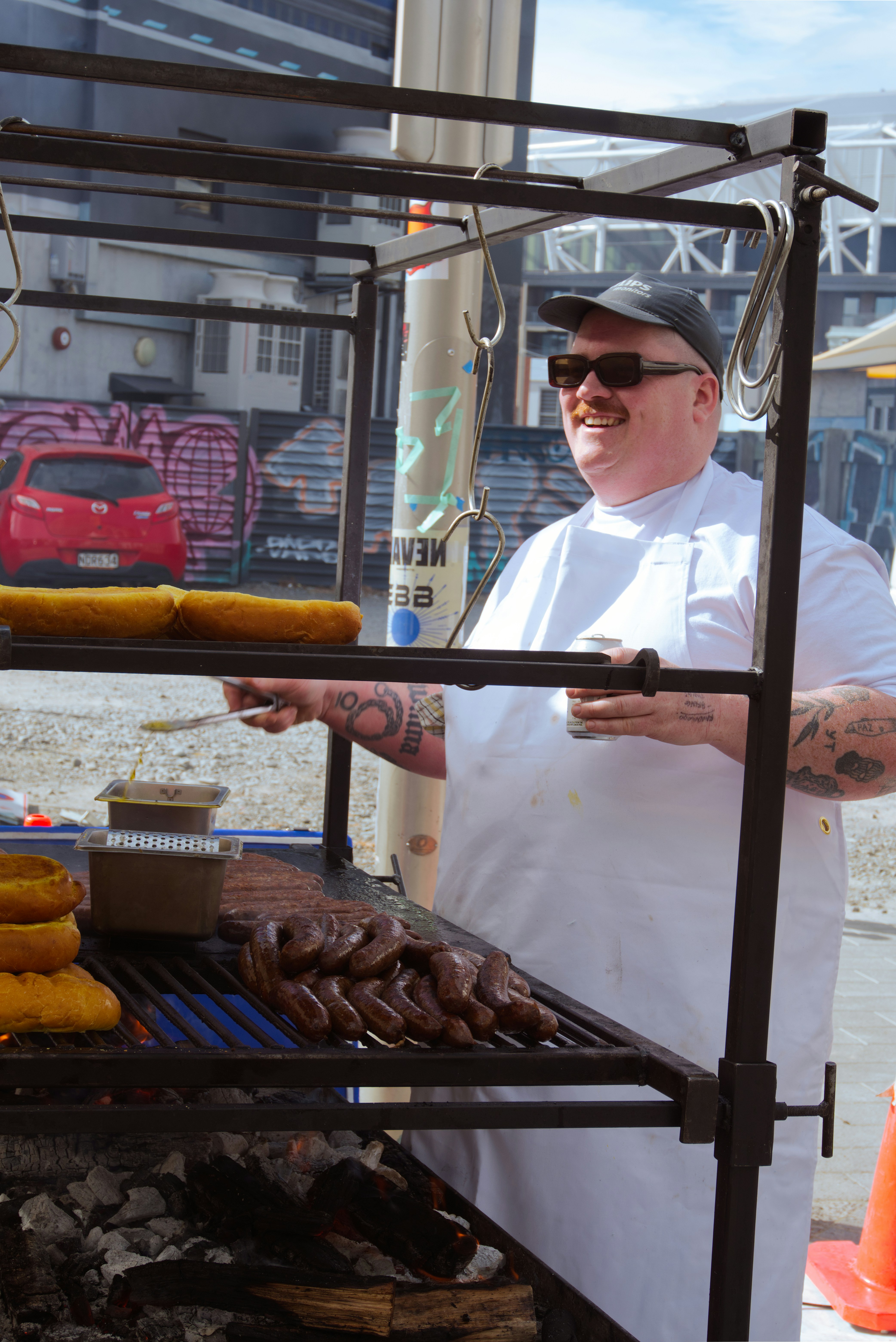 Grill Master in Action: Sausages Sizzle Under Market Light