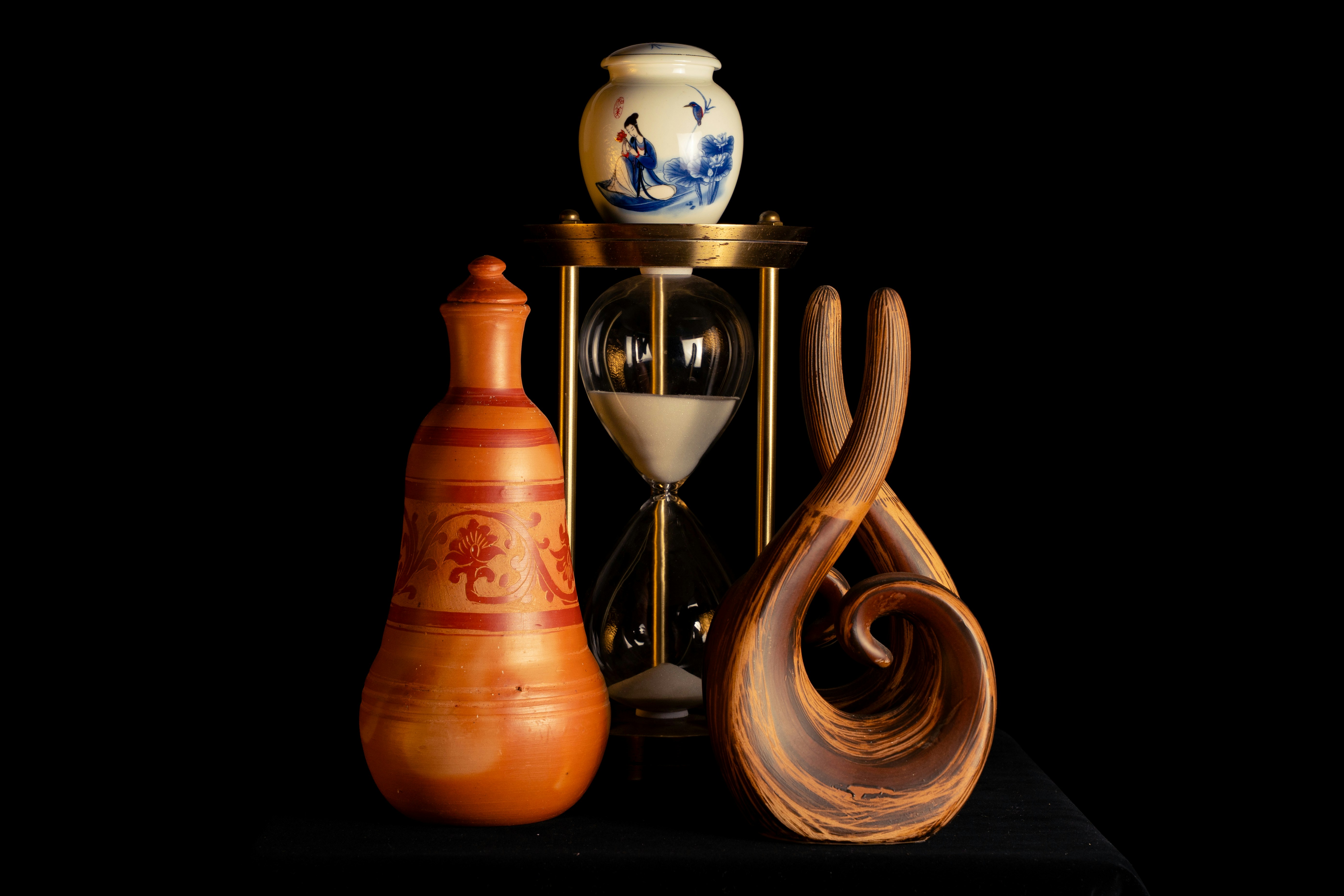 Ceramic Vase, Hourglass, and Curved Wood Sculpture: A Quiet Still Life of Contrast