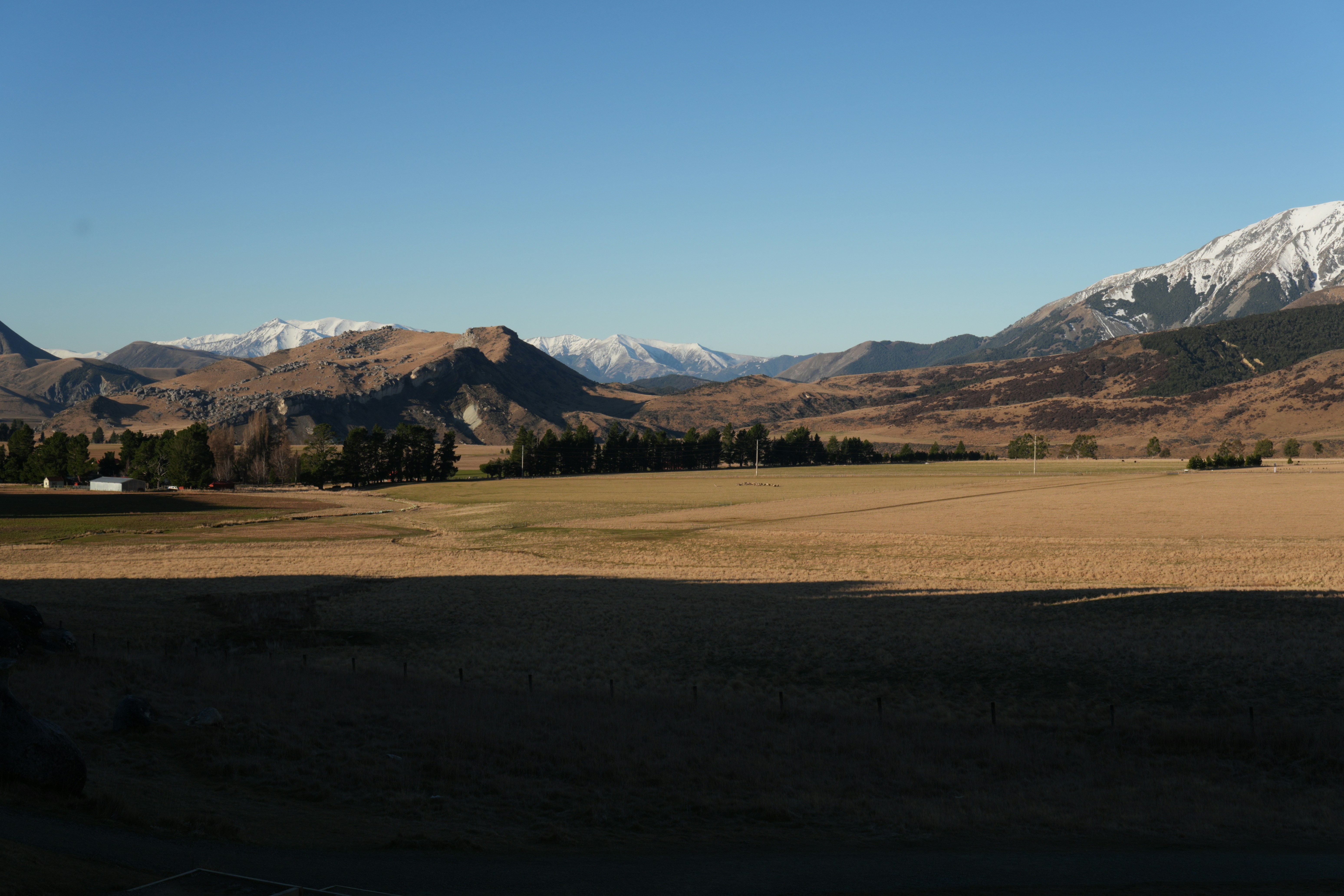 Snow-Capped Ridge at Dusk Over Golden Prairie