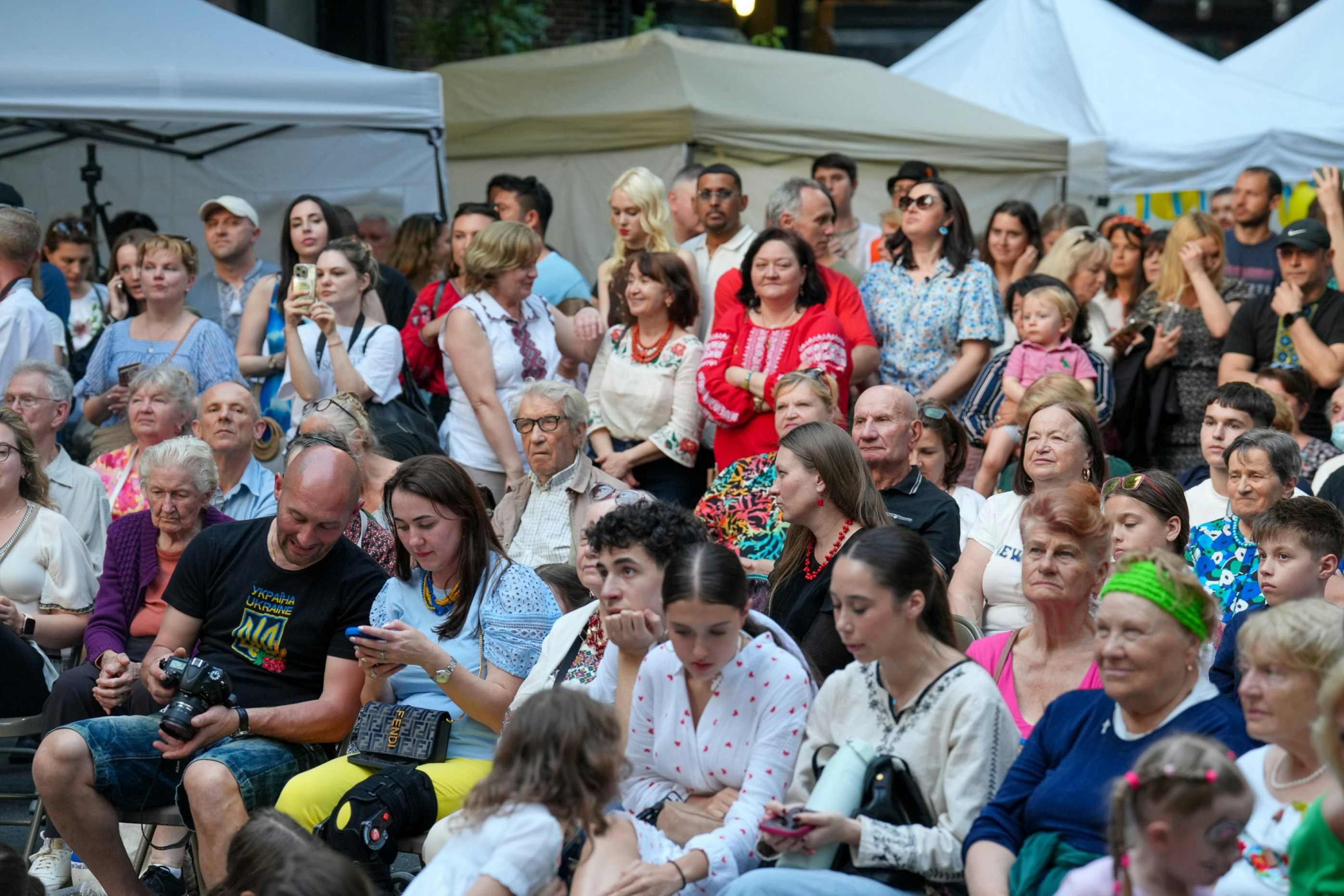 Sunlit Crowd at an Outdoor Market: Faces in the Front Row