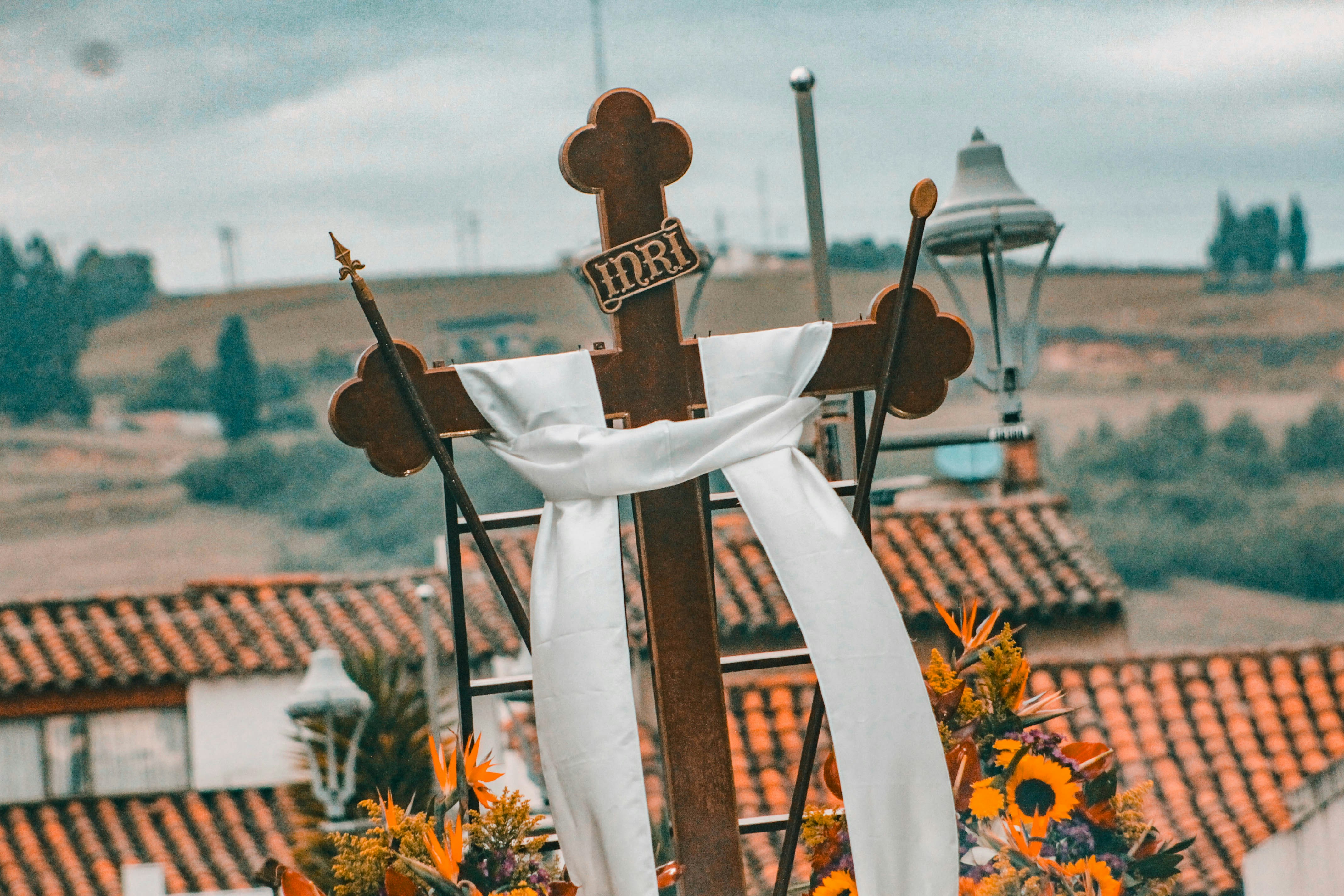 Crosses and White Ribbons: A Floral Ceremony Above the Tile Roofs