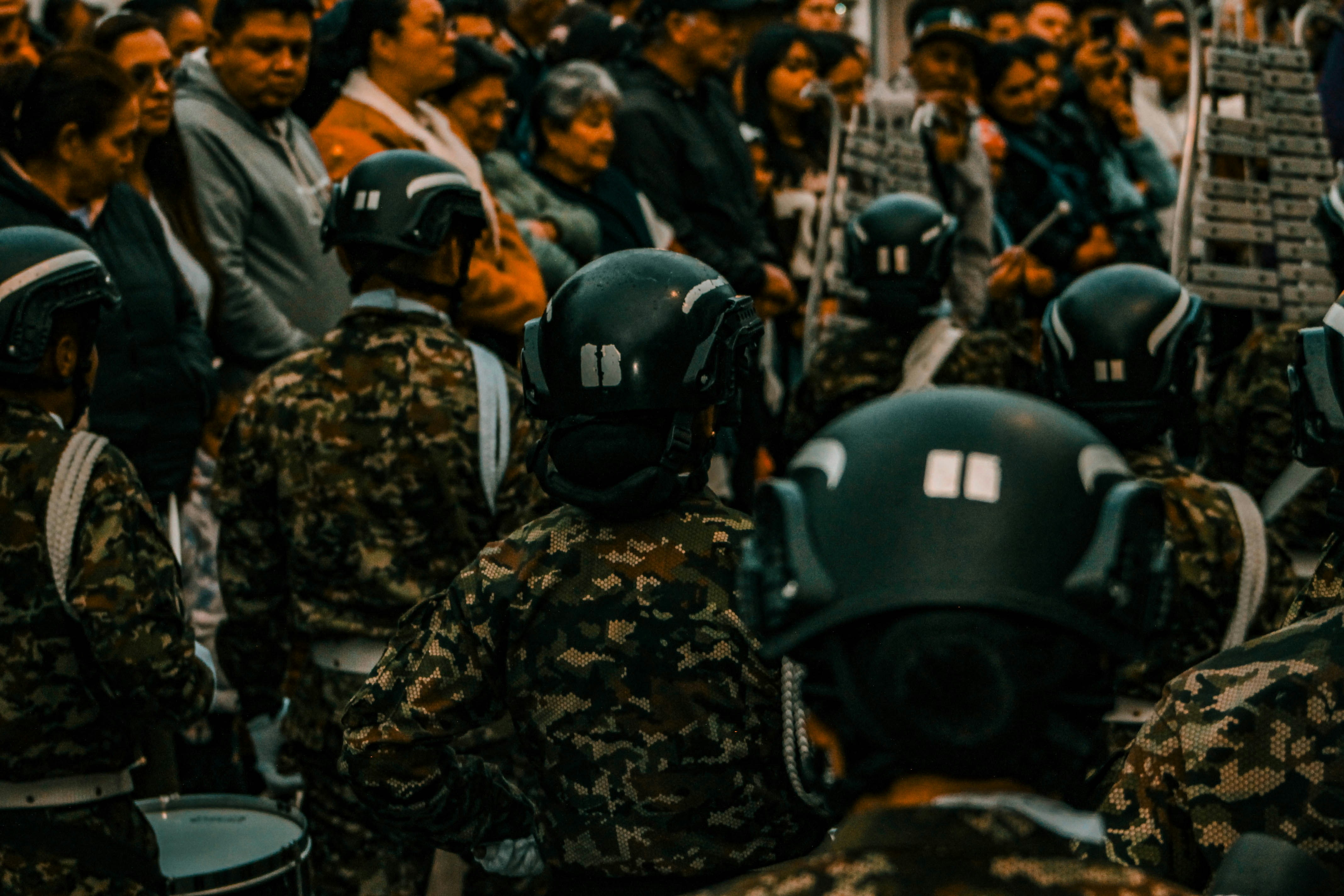 Marching silhouettes: a sea of camouflaged helmets in crowded street