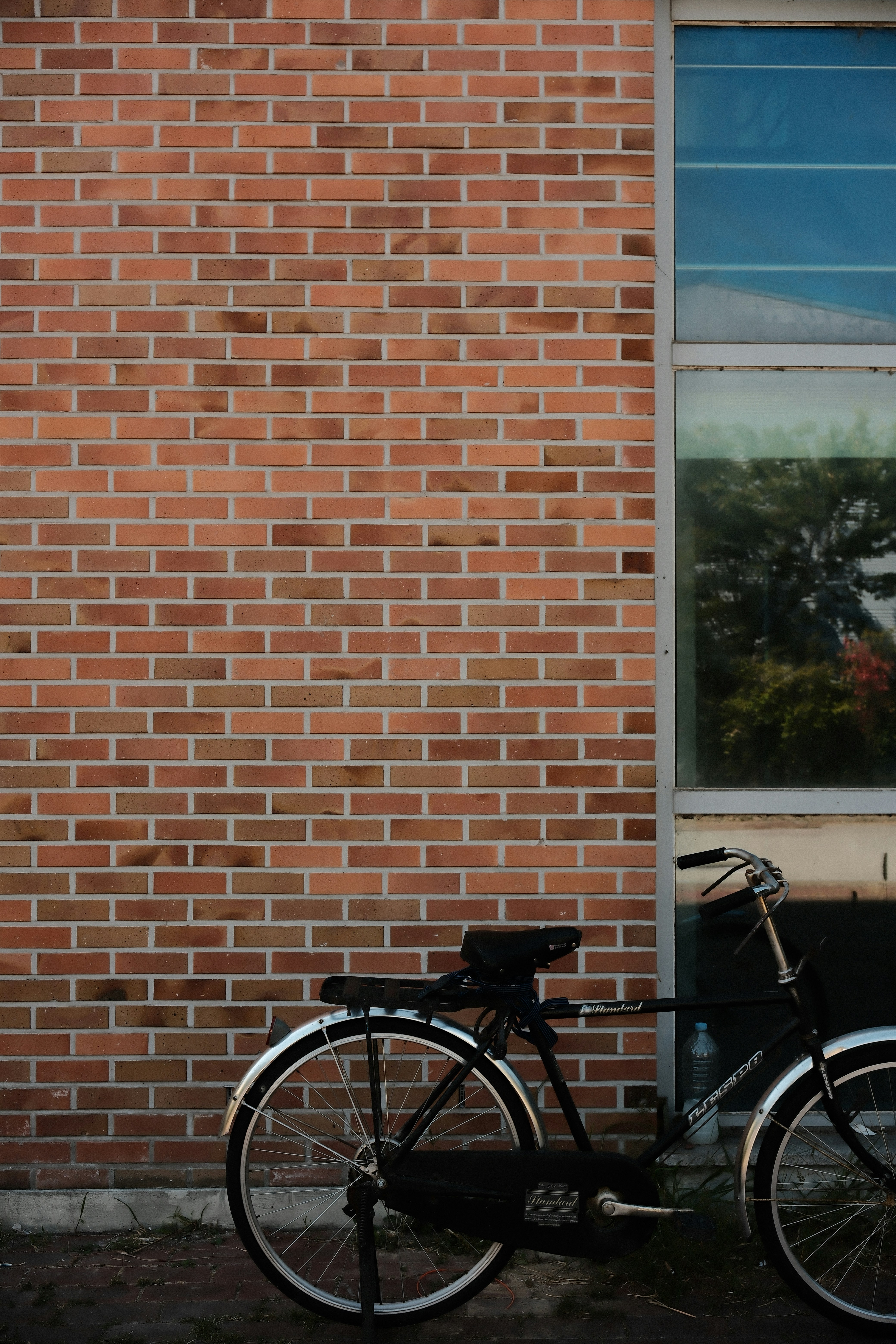 Bicycle Quietly Resting Against a Brick Facade