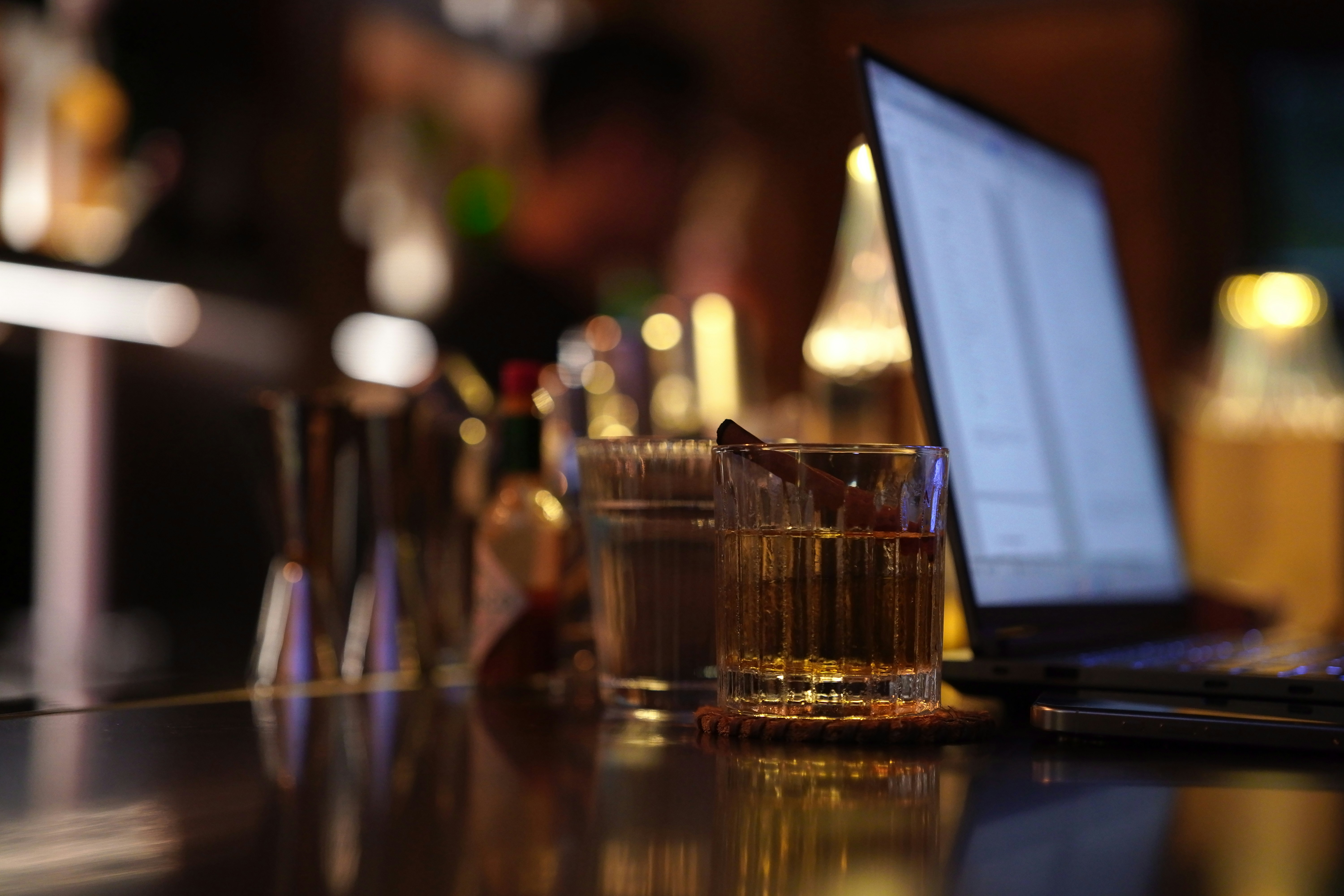 Dim Barside: Laptop Glares Over a Whiskey Glass