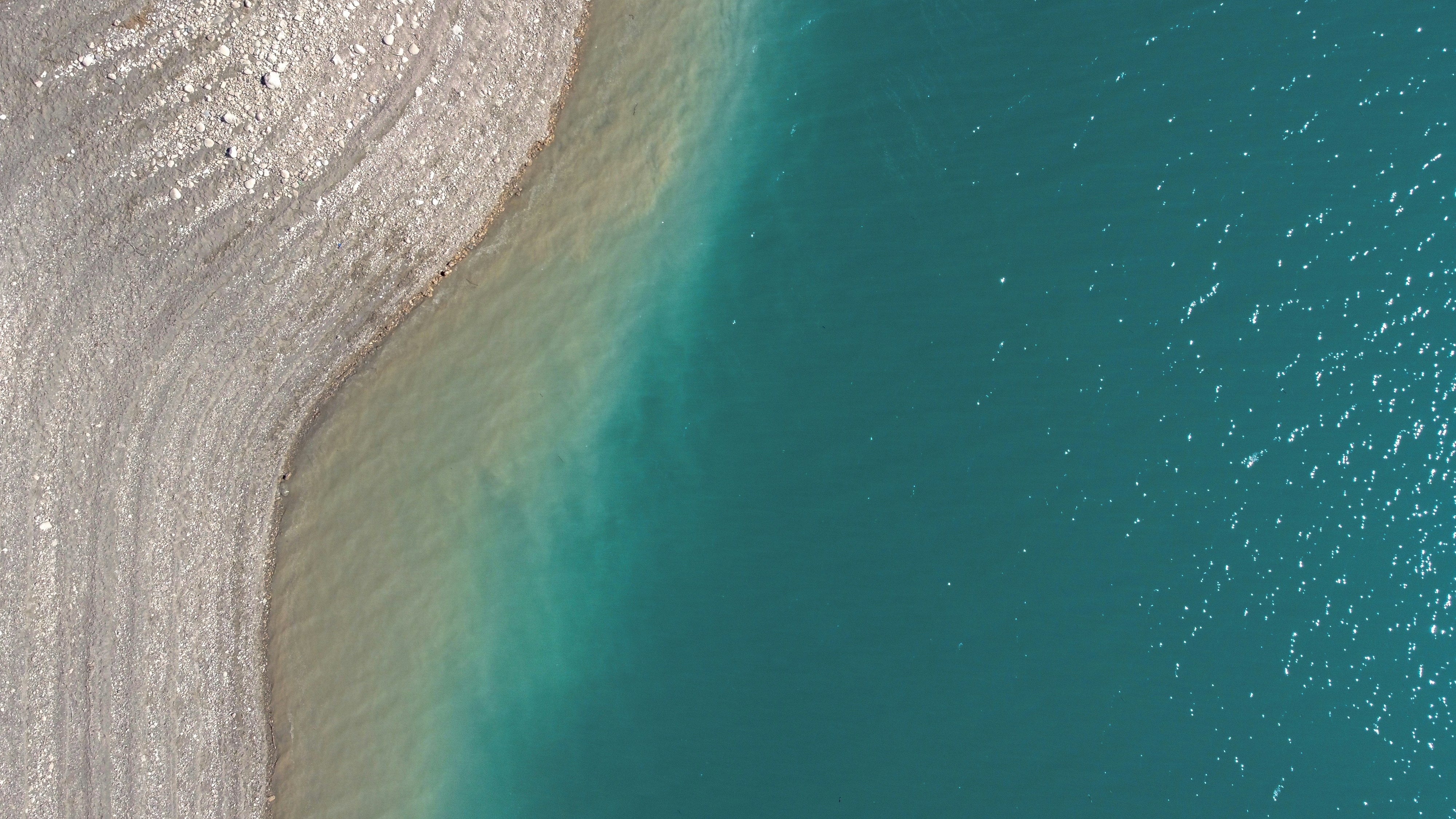 Shoreline Gradient: Turquoise to Sand at the Edge of Calm Waters