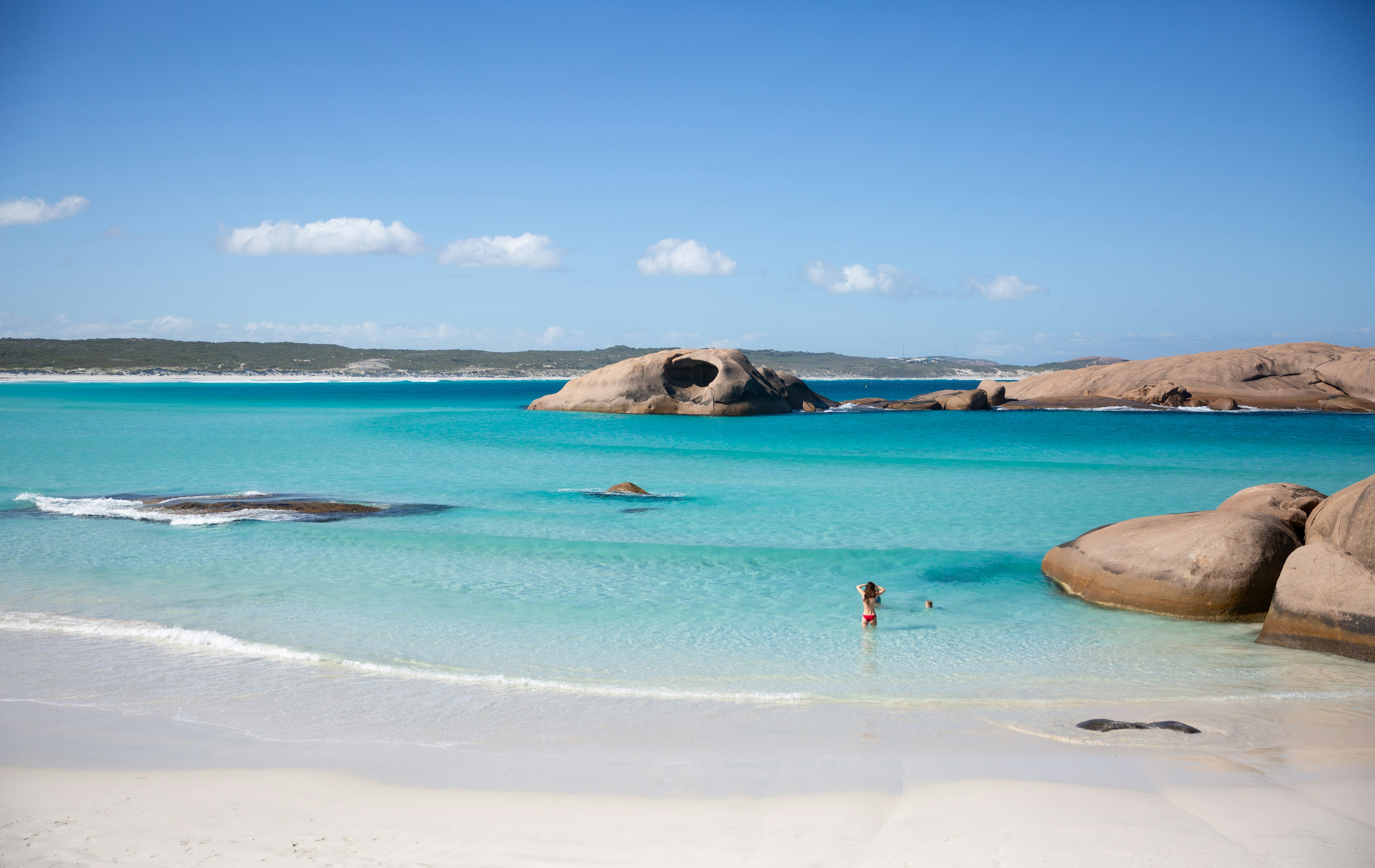 Turquoise Shoreline: A Lone Swimmer Beneath a Wide Atlantic Sky
