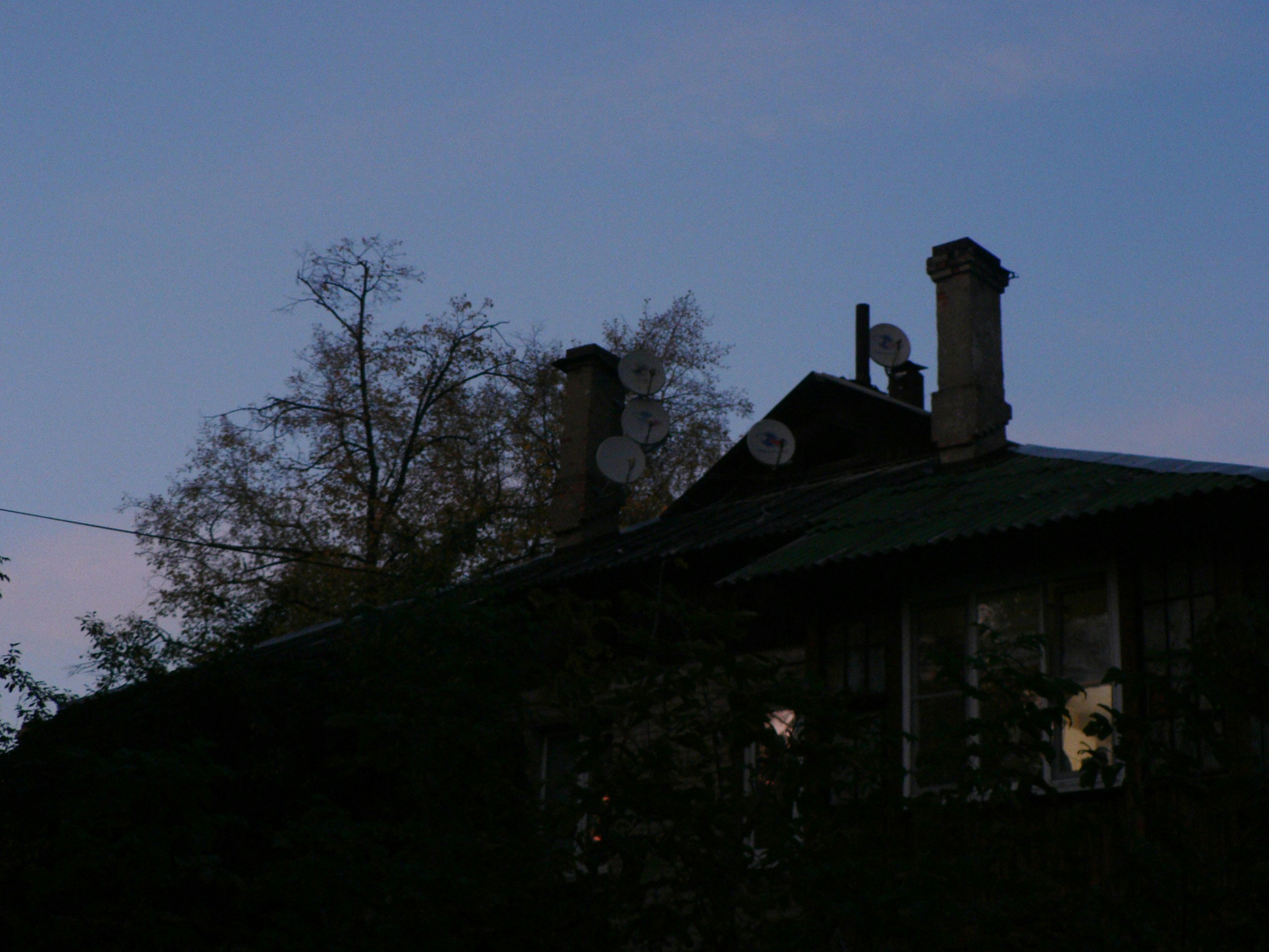 Moonlit Rooftops: Satellites and Chimneys in Twilight
