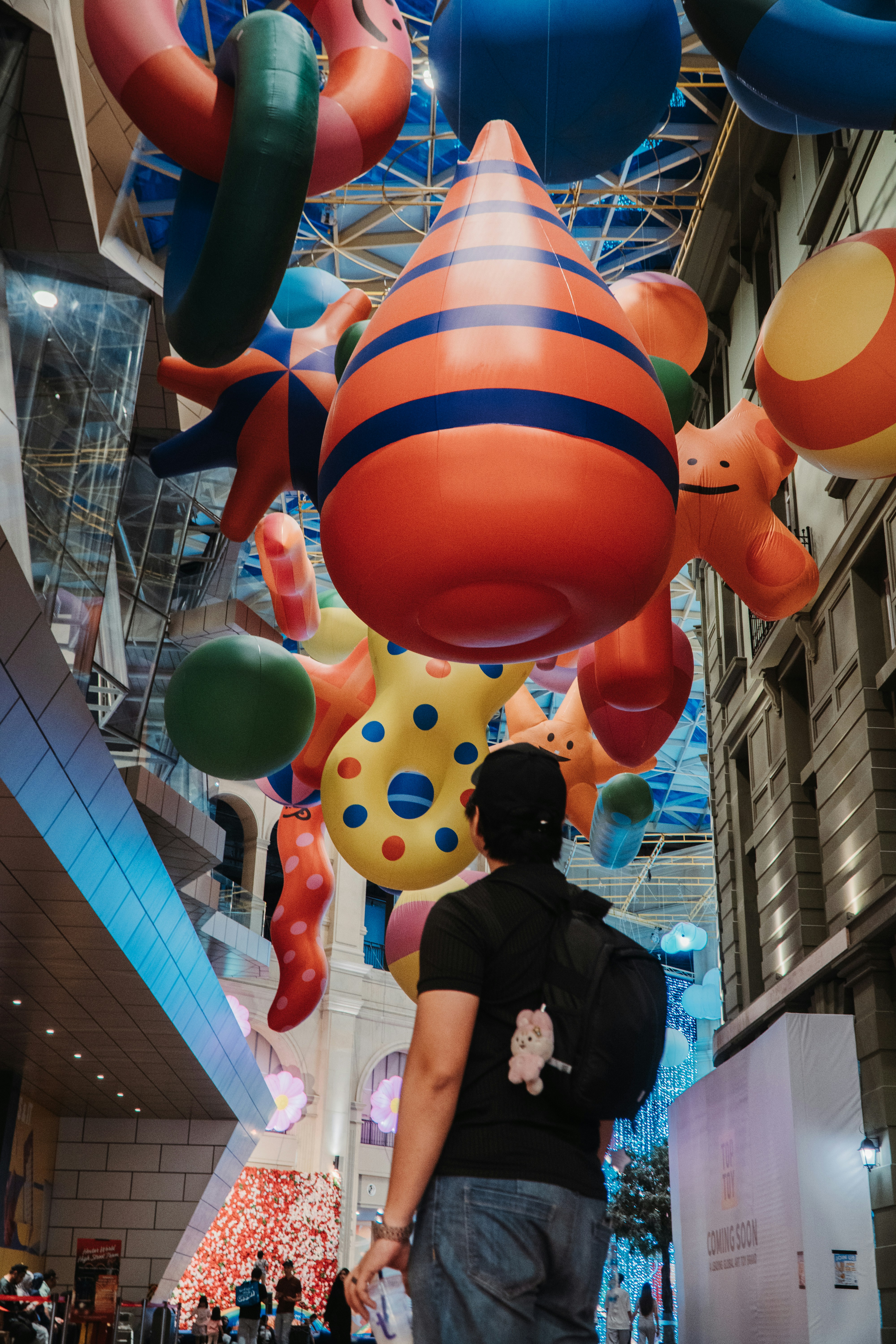 Floating Giants and a Lone Explorer in a Ceiling of Balloons