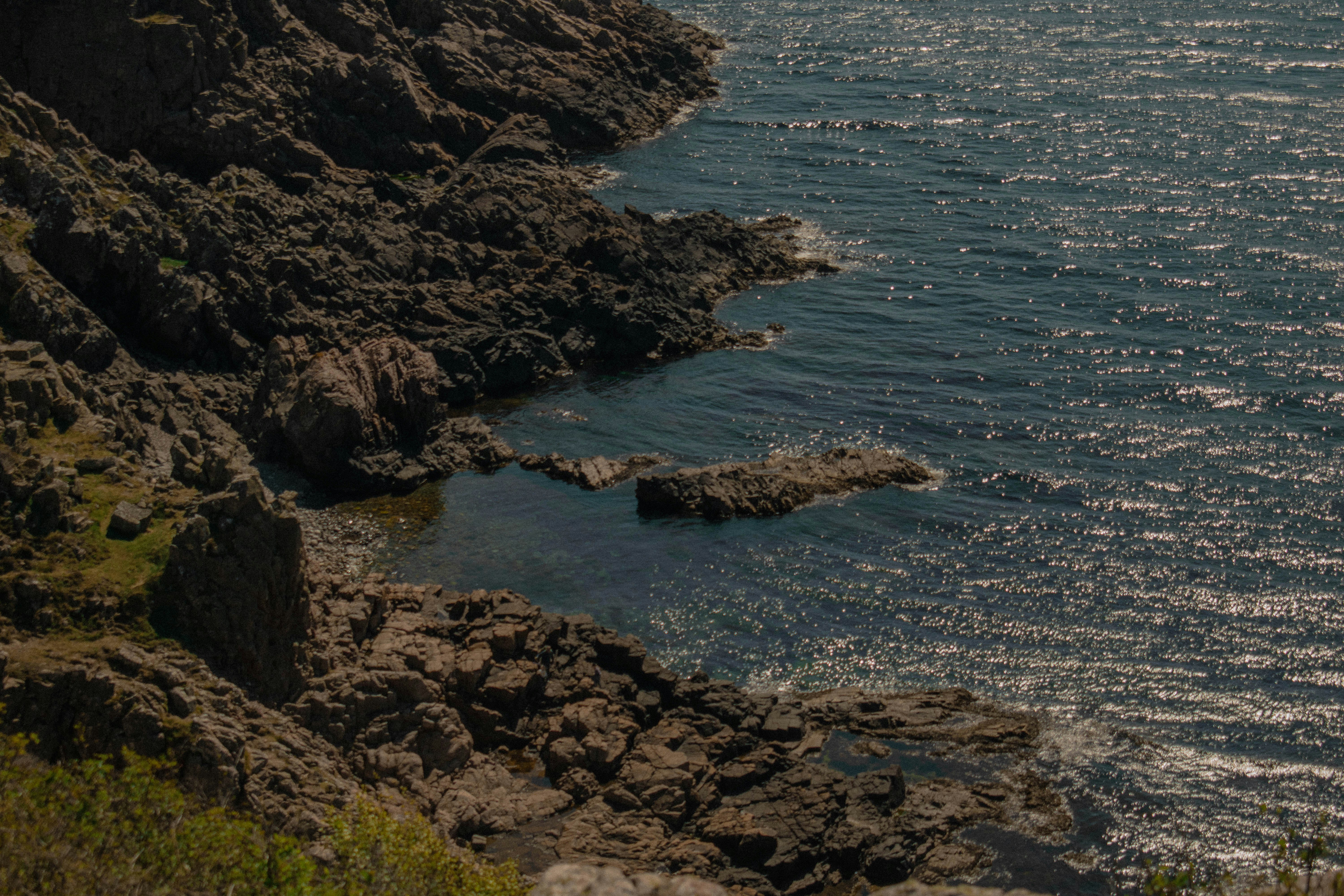 Sunlit Rocks and Surf at Quiet Coastal Edge