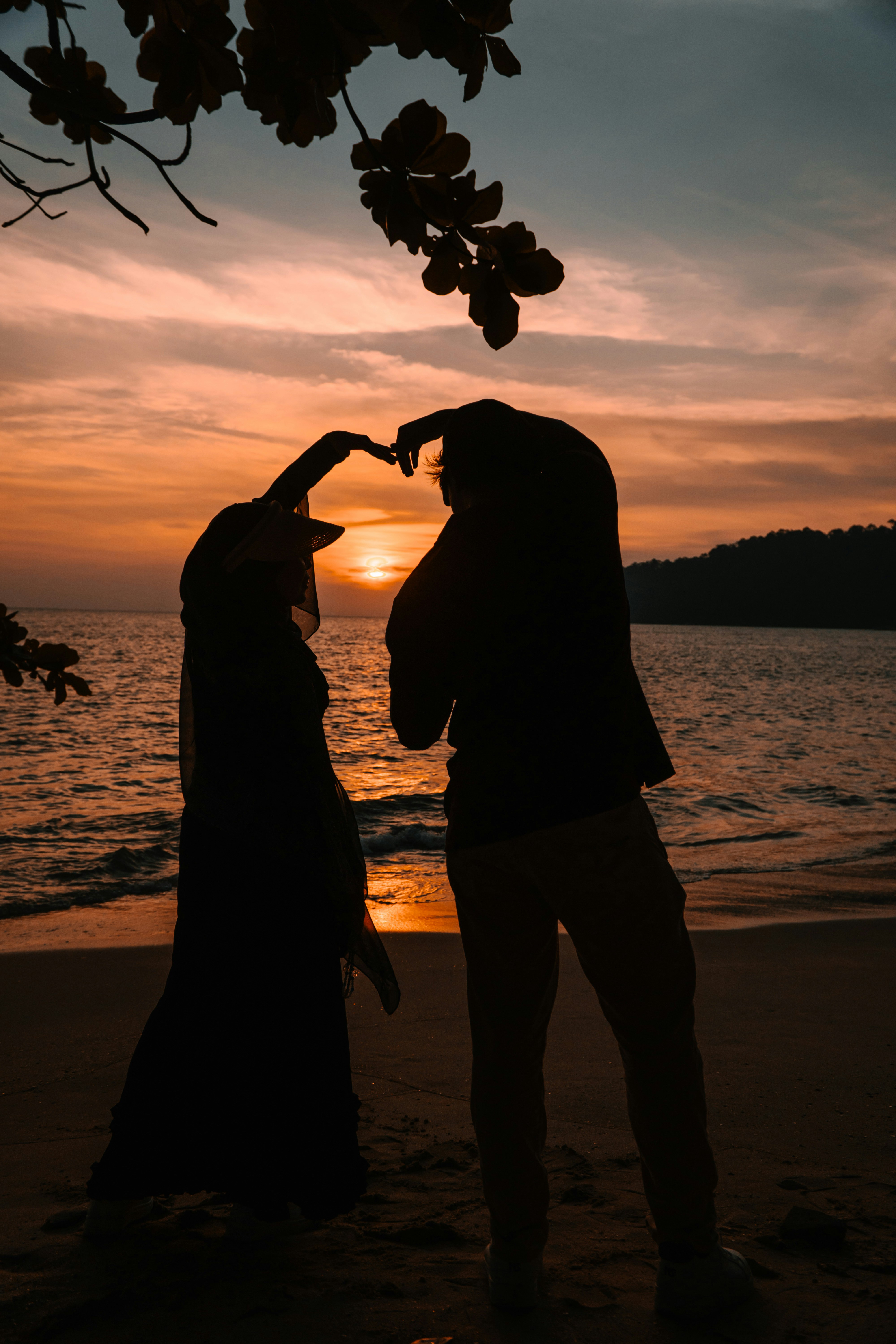 Sunset Silhouette: Lovers Casting a Heart at the Shore