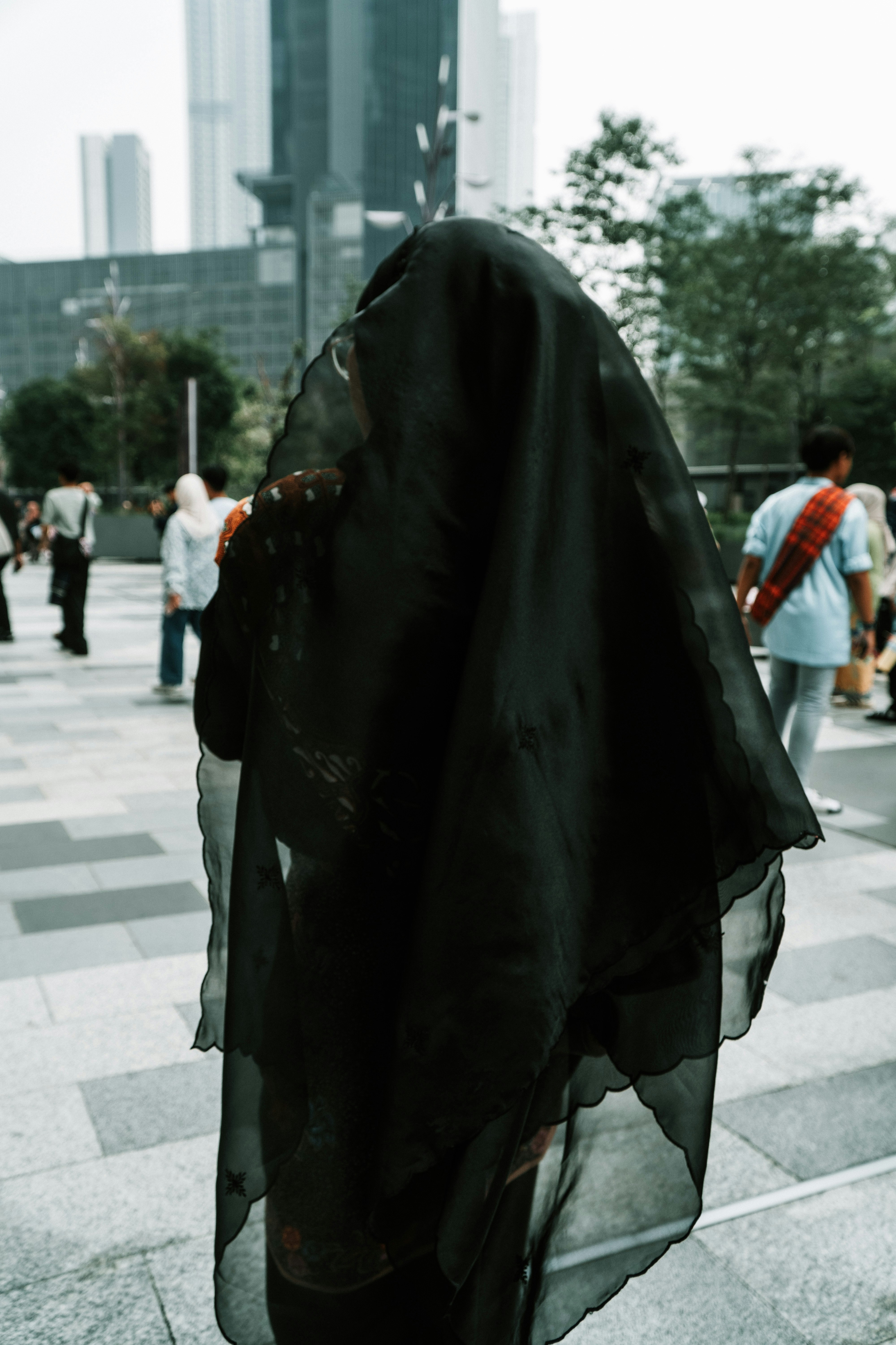Silhouette in the City: Veiled Presence Amid Urban Pulse