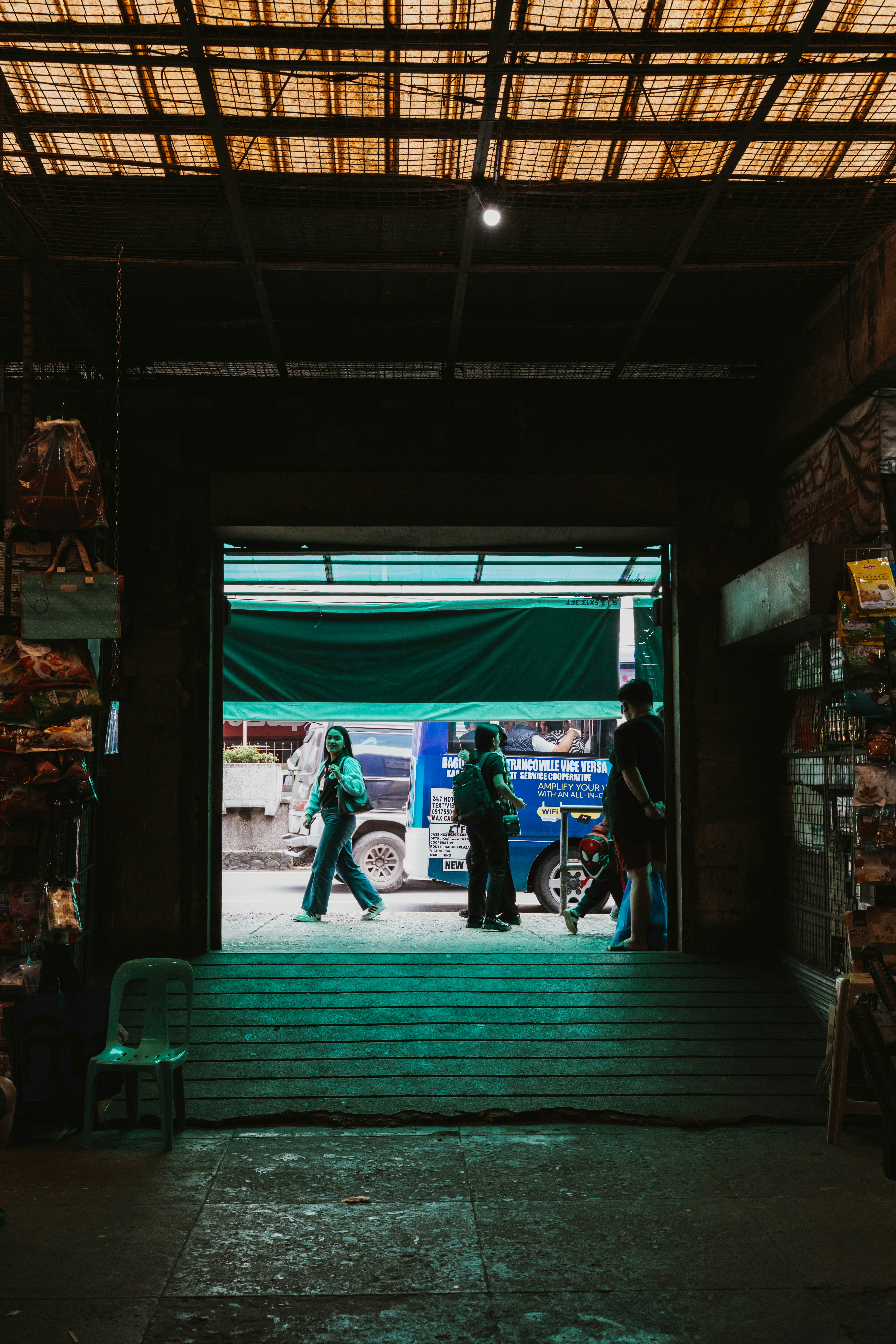Hushed Threshold: Foot Traffic Between a Market Stall and Sunlit Street