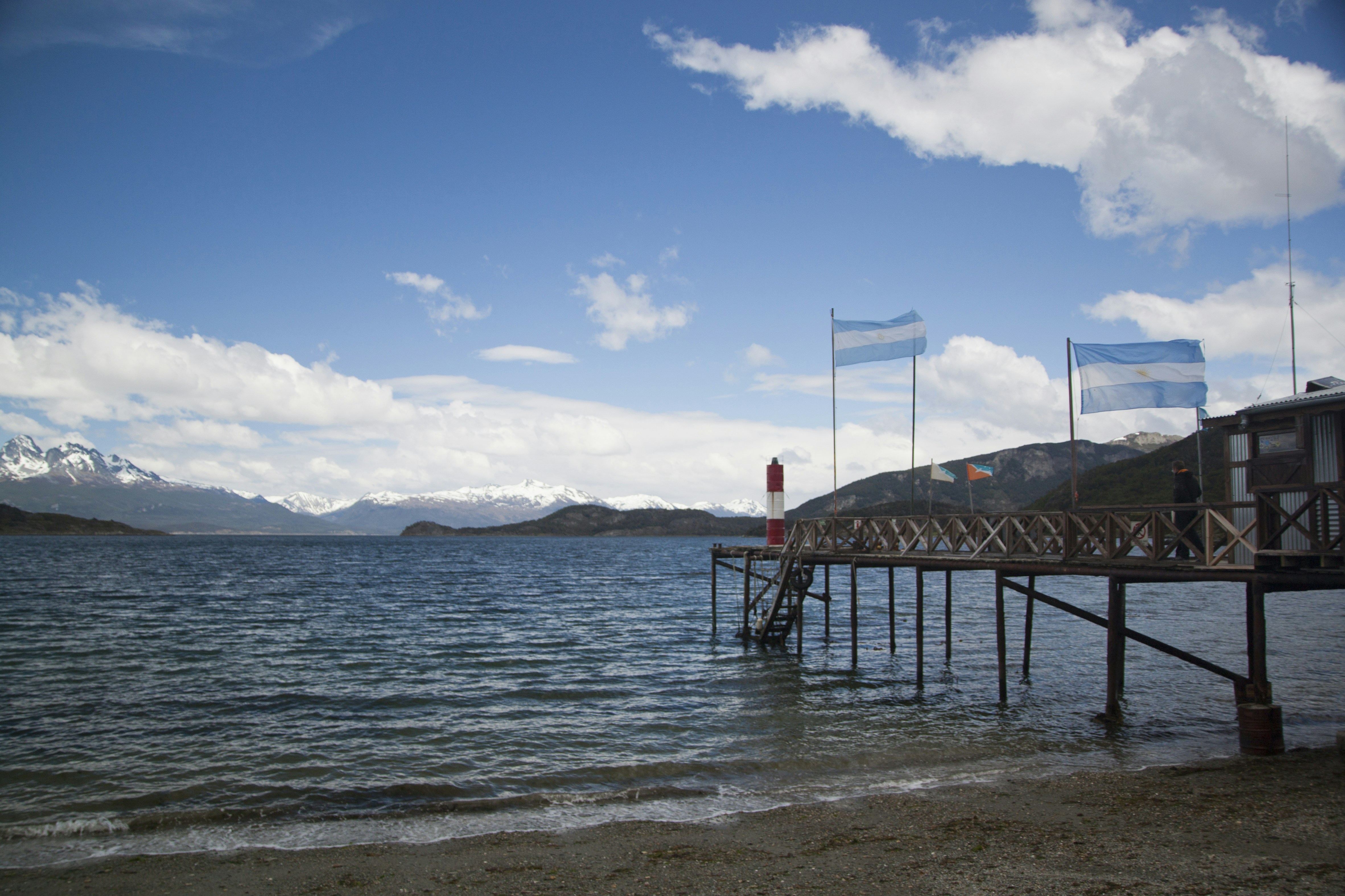 Pier to the Horizon: A Alpine Lakeside Scene with Flagged Dock