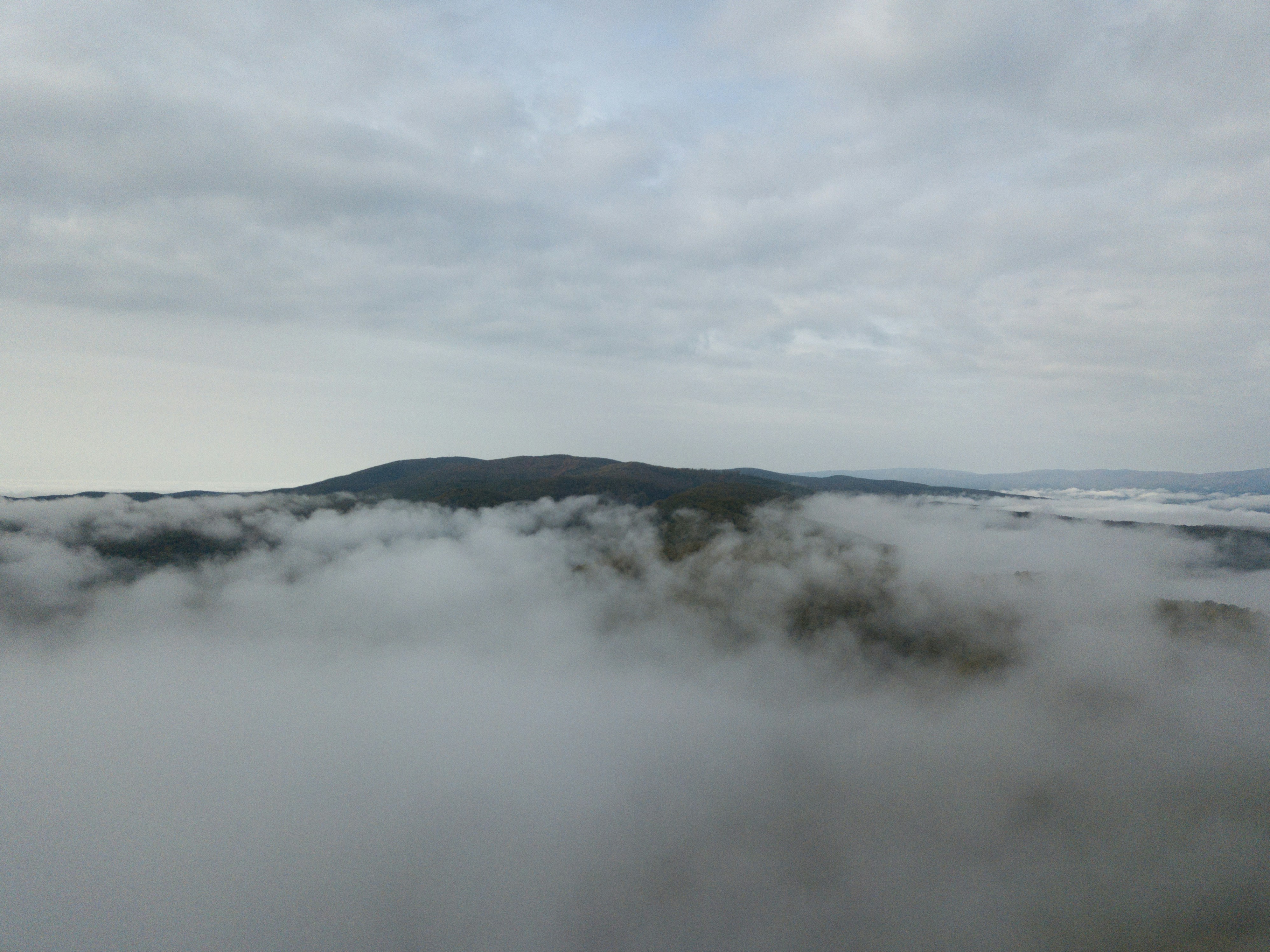 Misty Crest: A Lonely Ridge Emerging through Low Clouds
