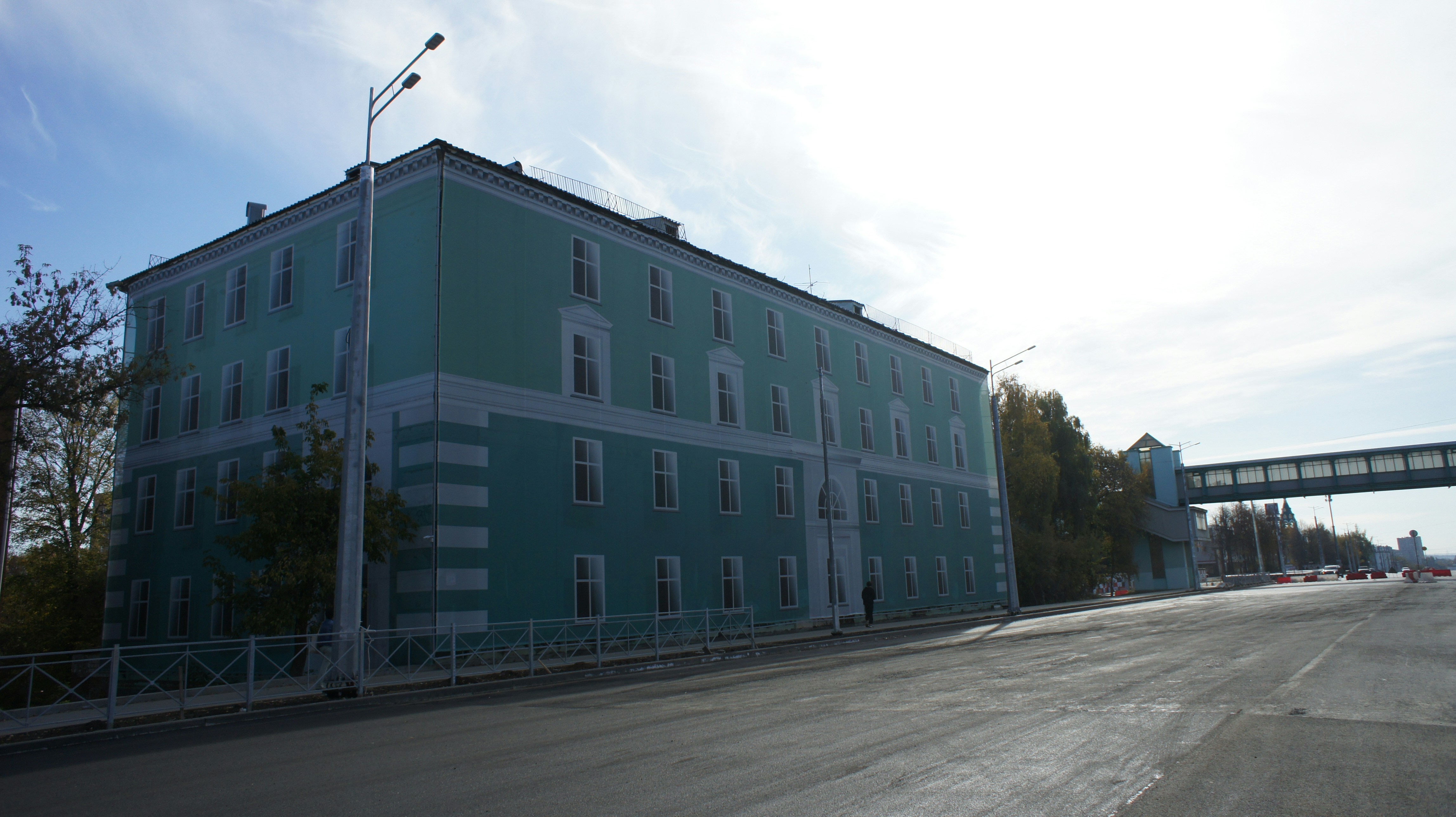 Minted Facade by the Avenue: A Quiet Street Feeding a City Sky
