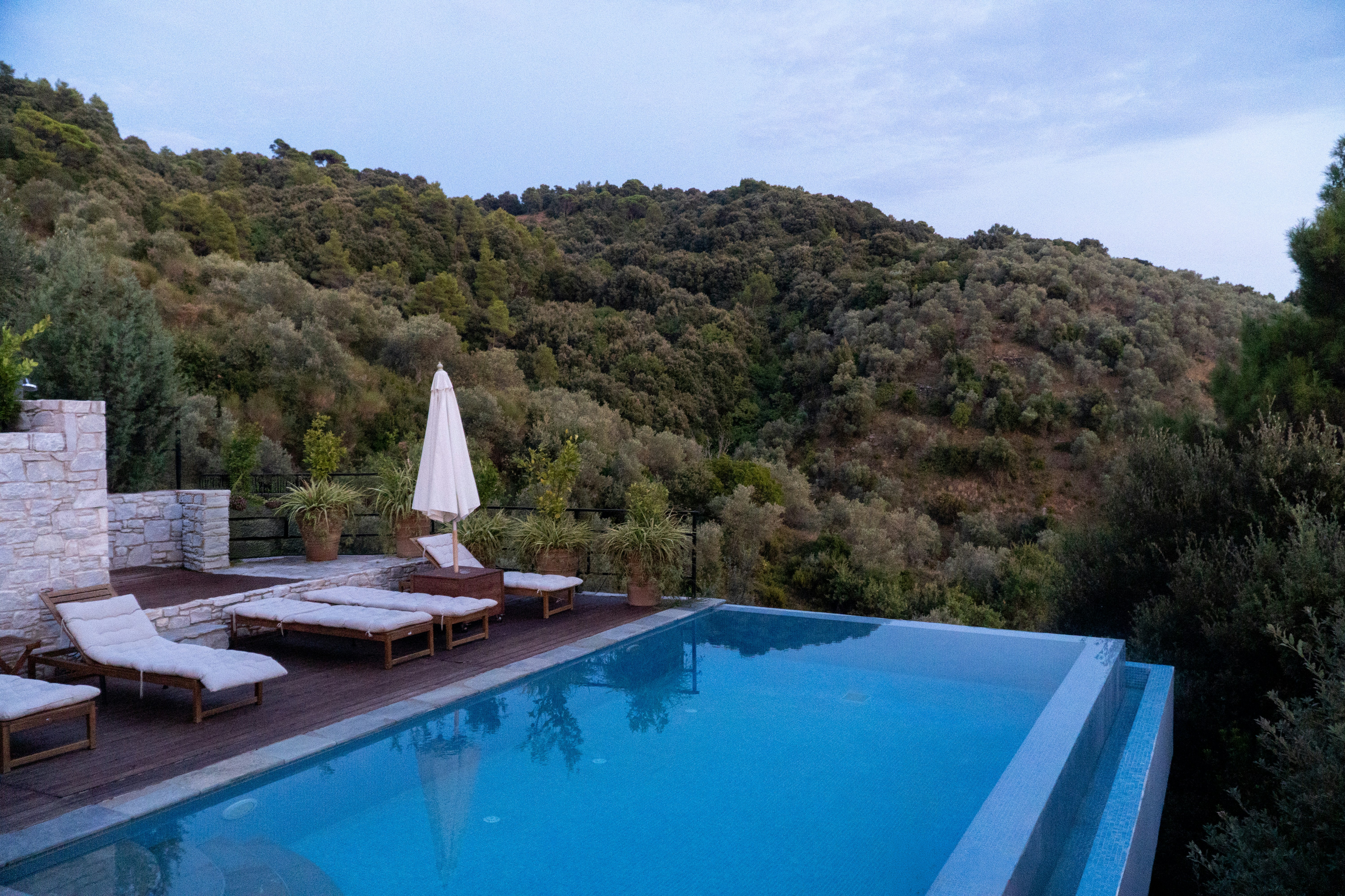 Infinity pool and lounge deck overlooking a Mediterranean hillside.