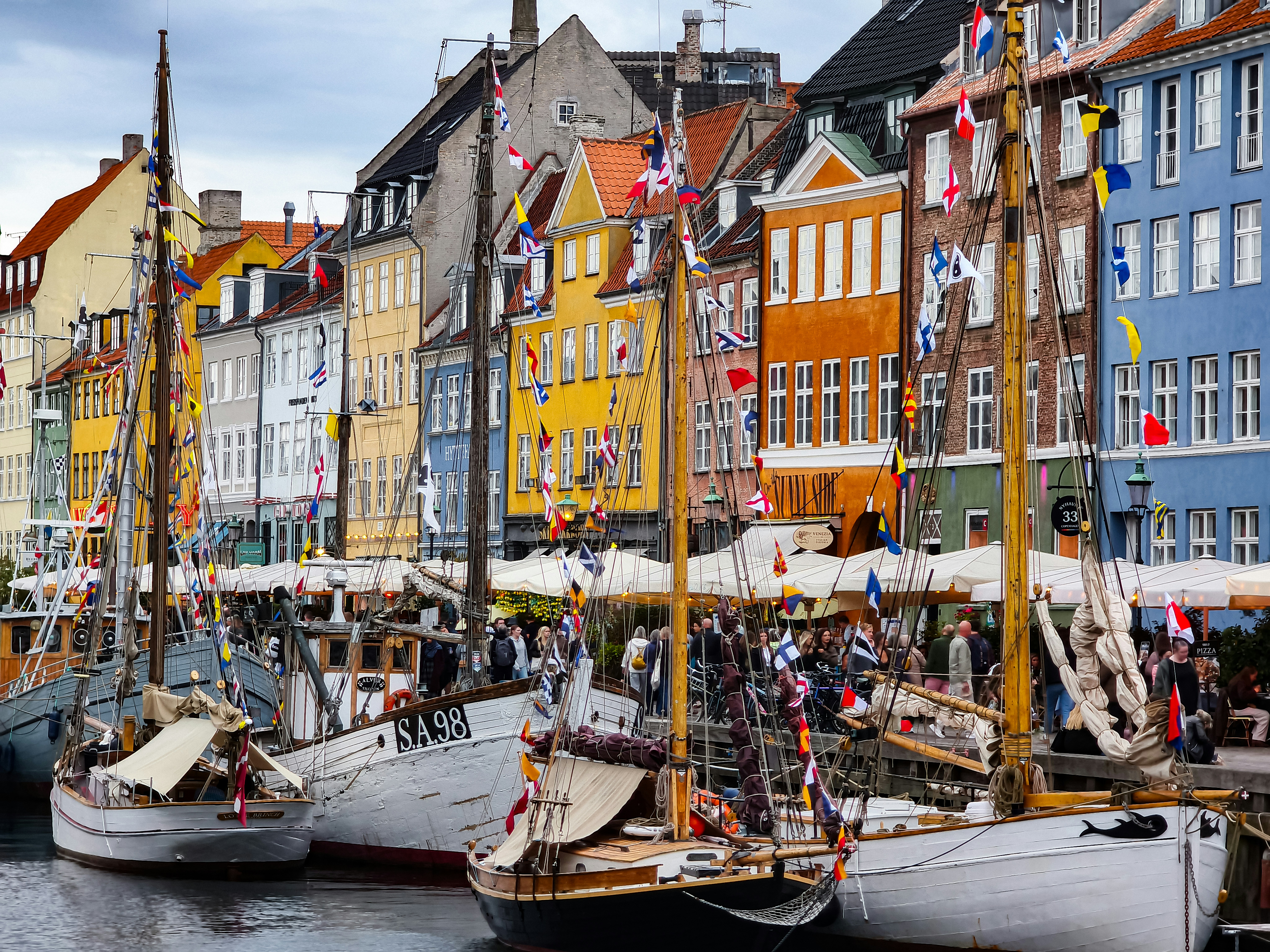 Vibrant harbor: colorful facades and sails under a festive banner