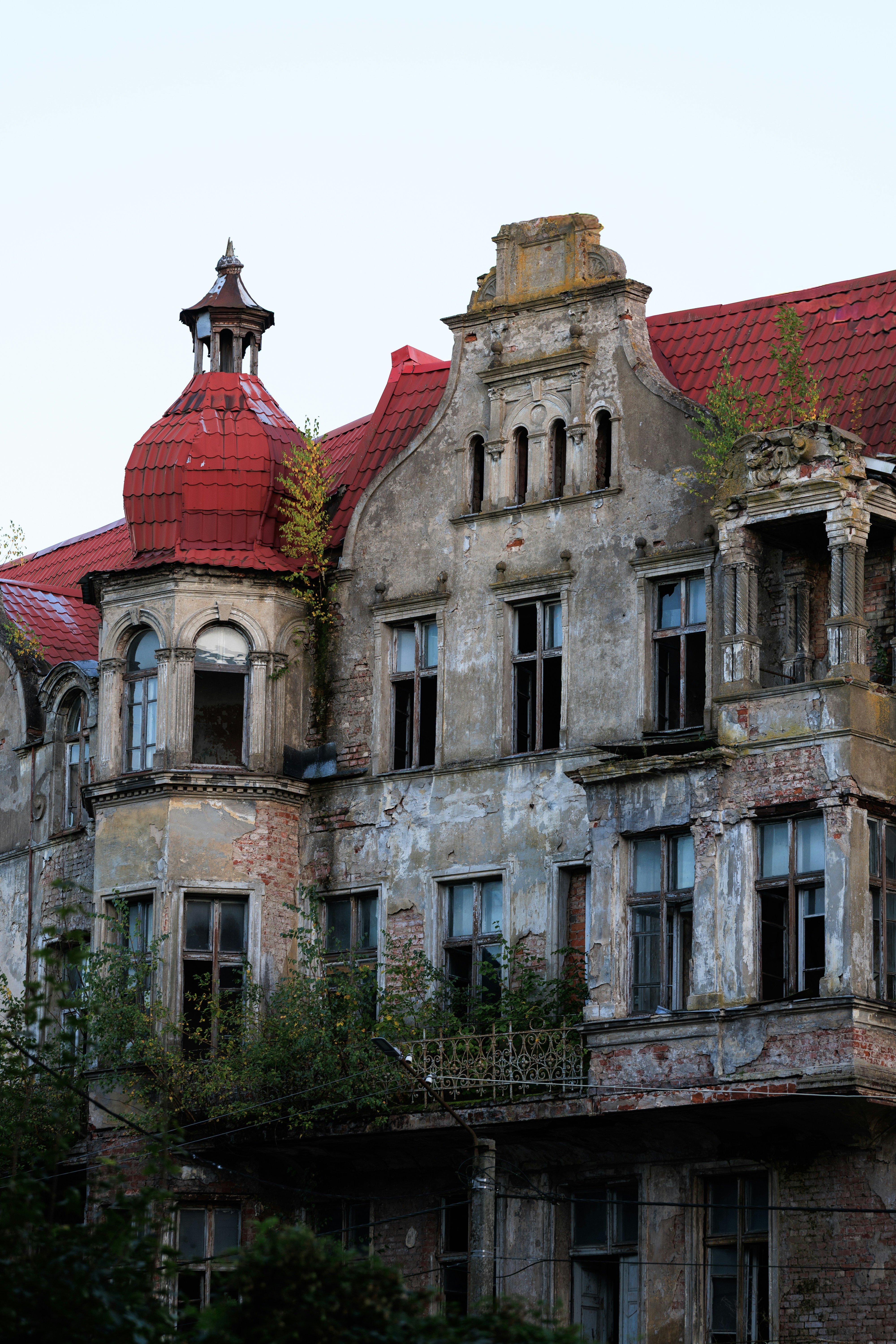 Crumbled grandeur: a decaying turreted facade against a weathered roofline