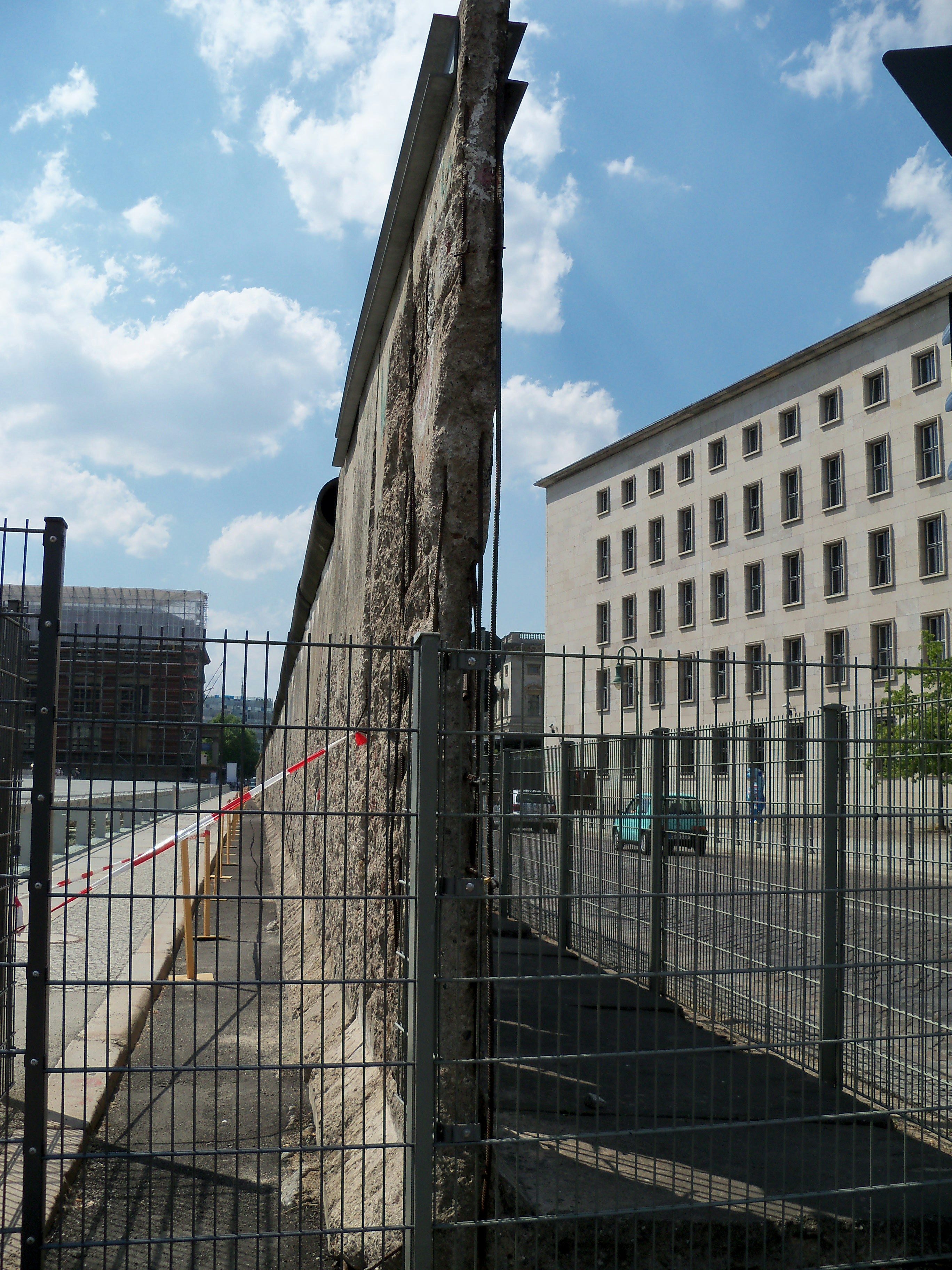 Cracked Barrier: A City Wall Framed by Fences and Buildings