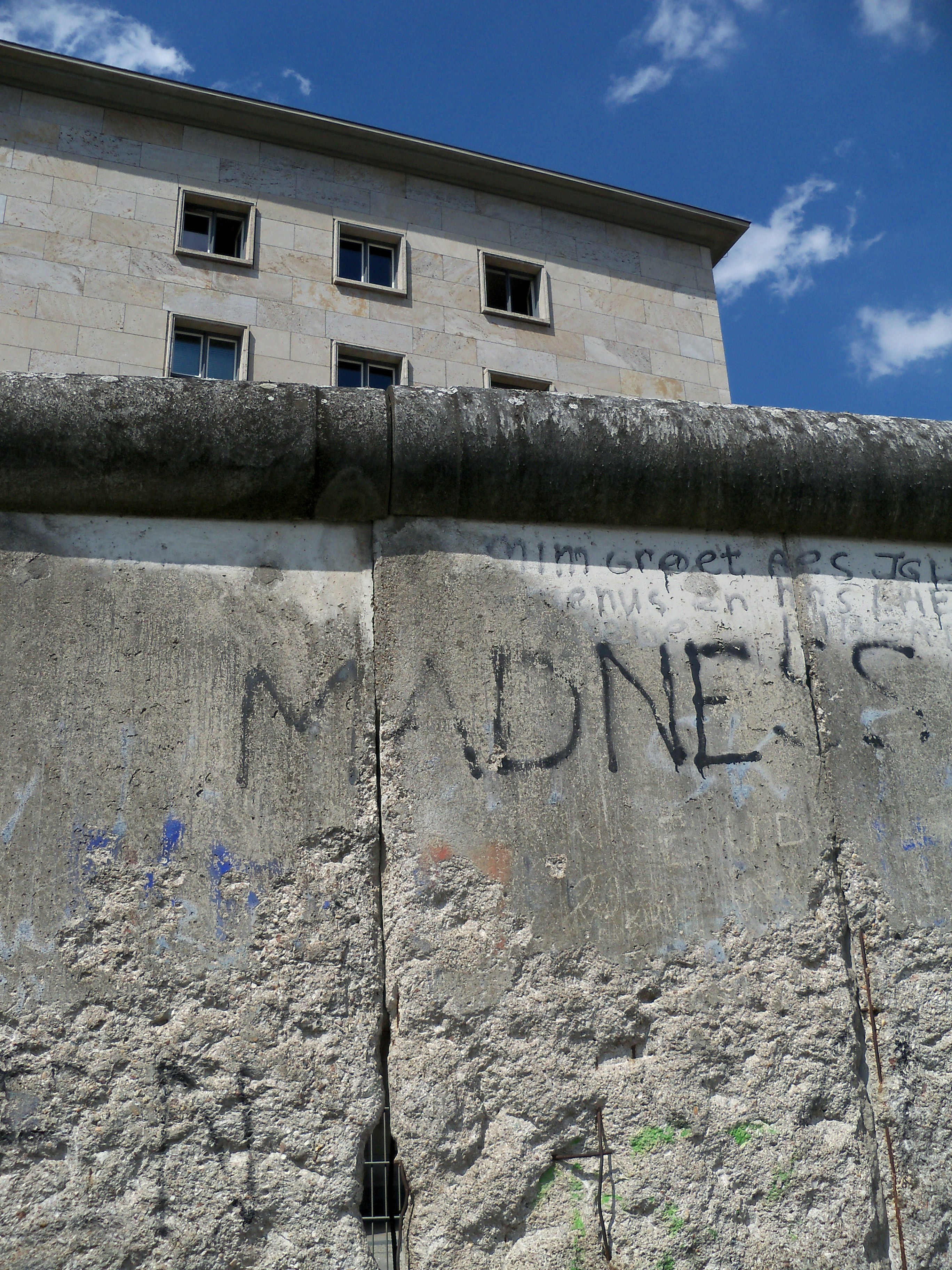 Concrete Barrier and Aged Facade Under a Clear Sky