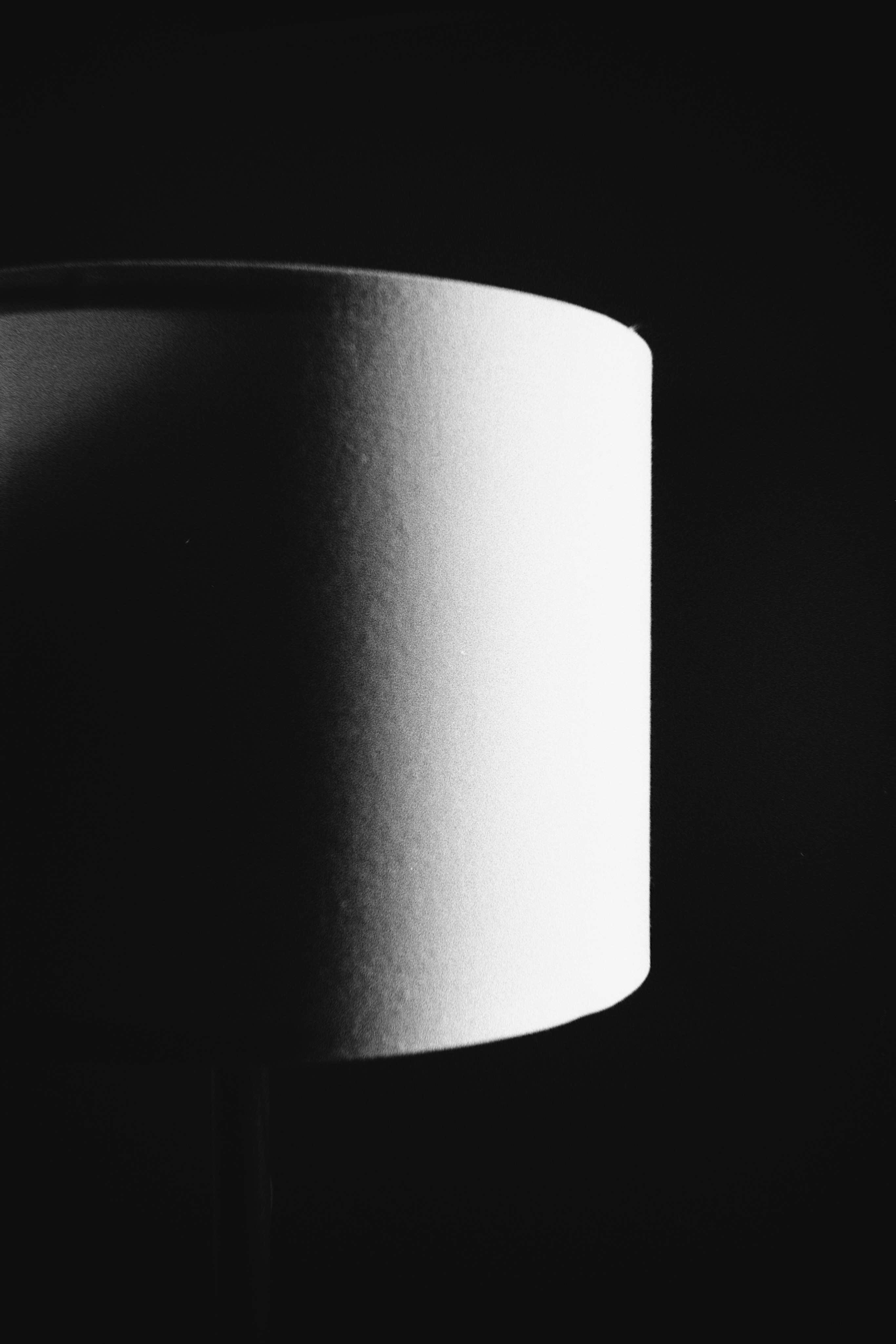 Haloed Cylinder in Void: A Mono Lamp on the Edge of Darkness