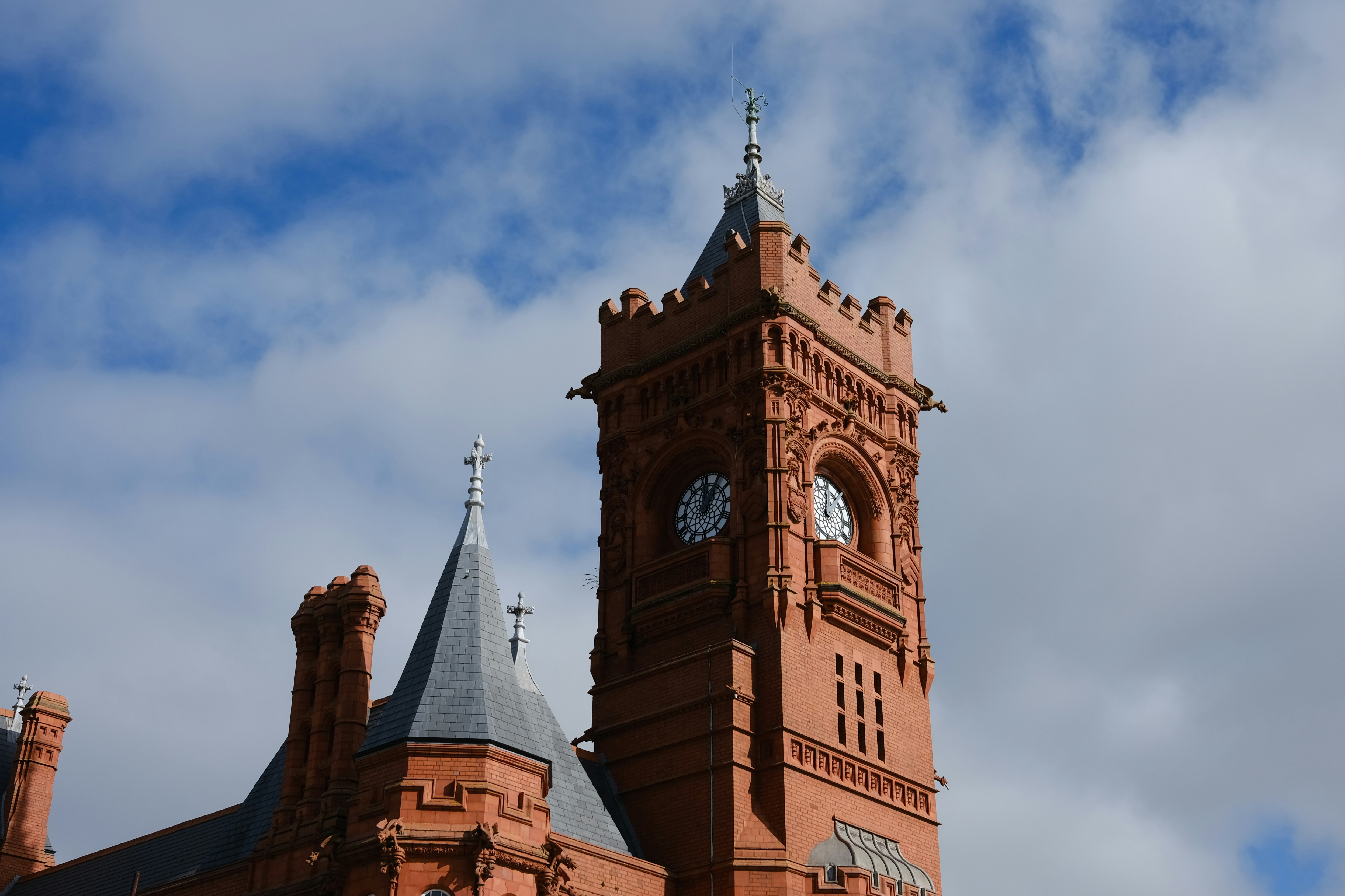 Red Brick Clock Tower Reaching Toward a Sky of Clouds