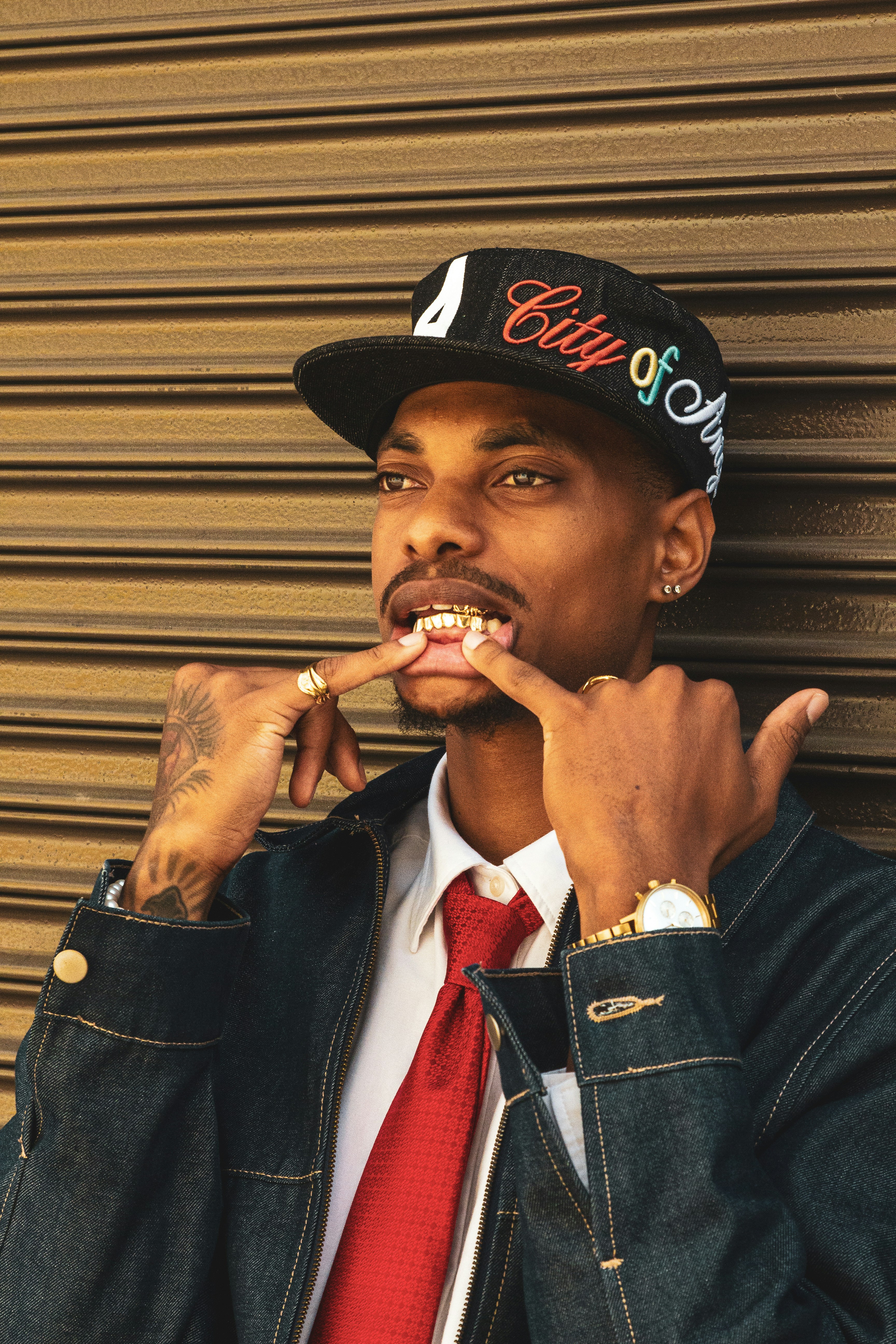Gold Chains, Street Vibe: A Confident Portrait in Front of a Rusted Shutter