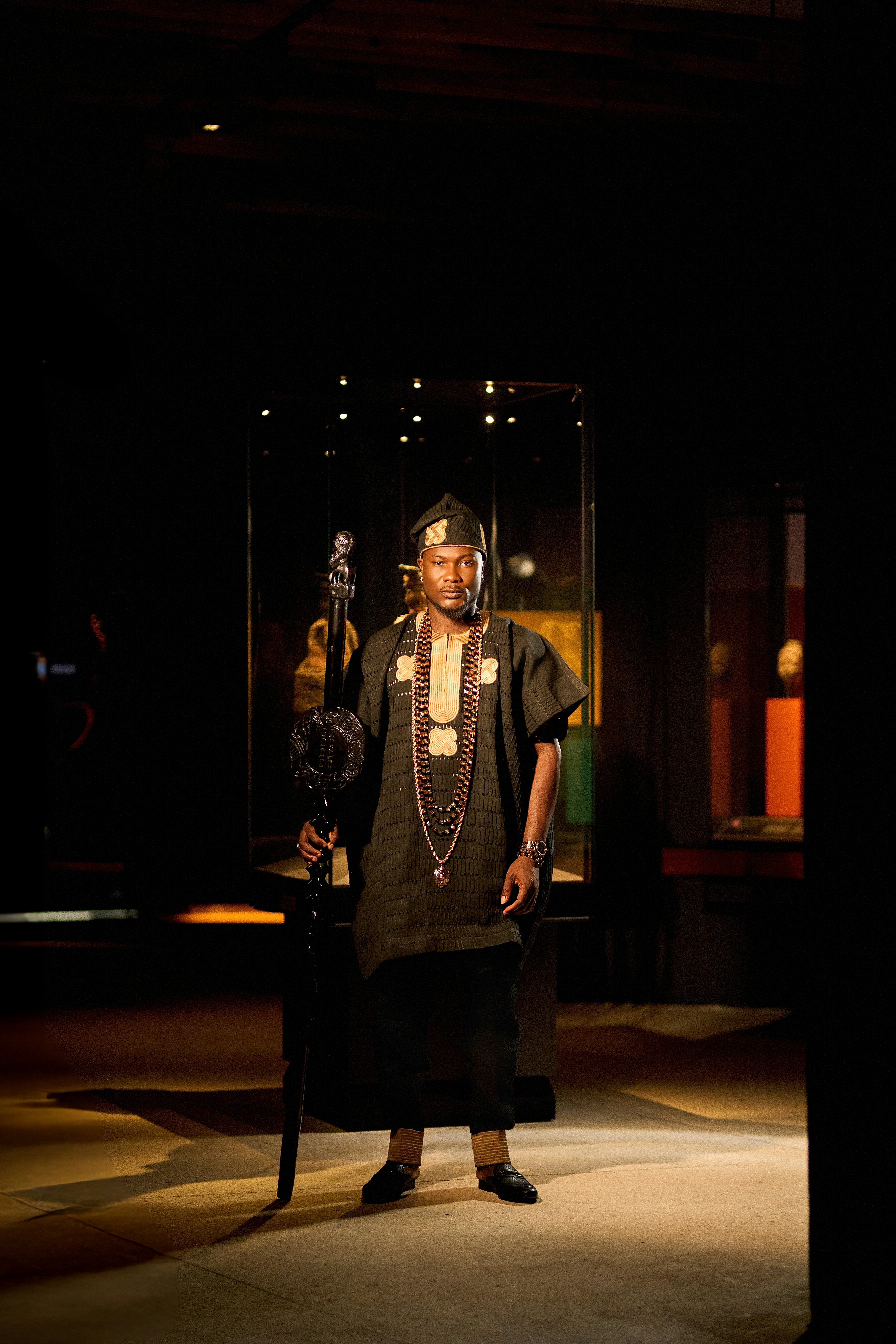 Guardians of Heritage: A ceremonial figure in a glass-draped gallery