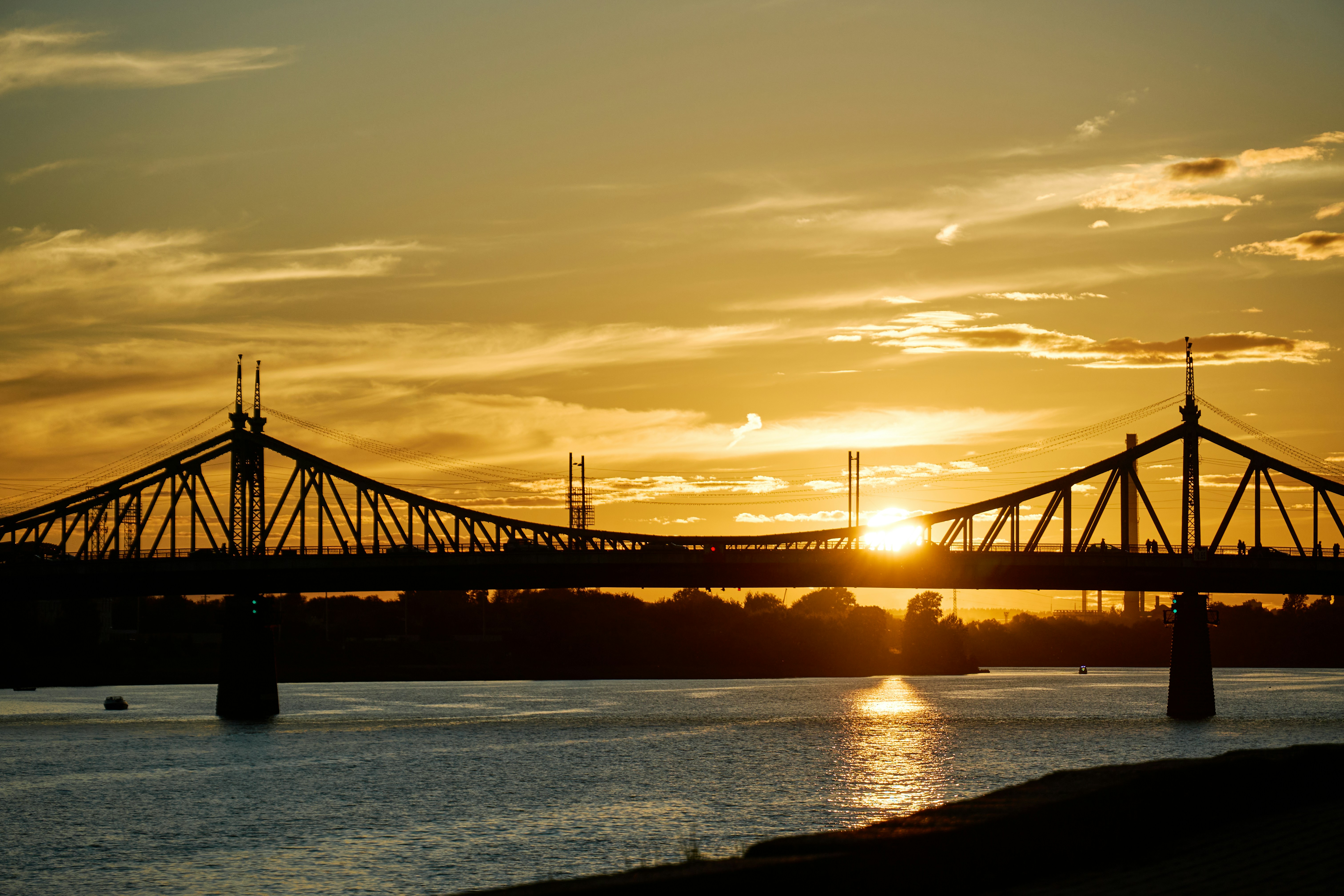 Sunlit Silhouette: A River Dawn Beneath the Truss Bridge