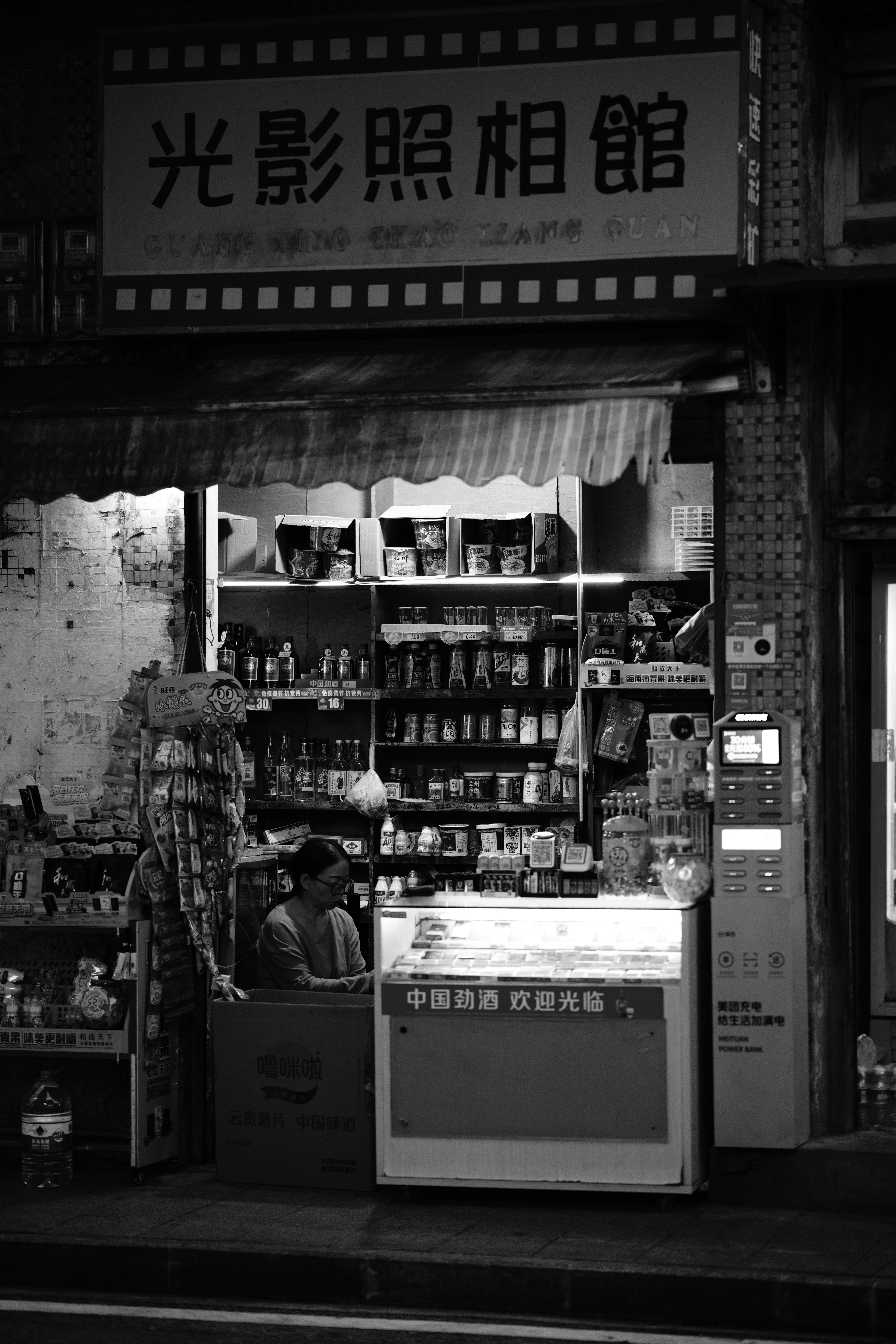 Neon-lit storefront: a quiet snack stand beneath a Chinatown sign