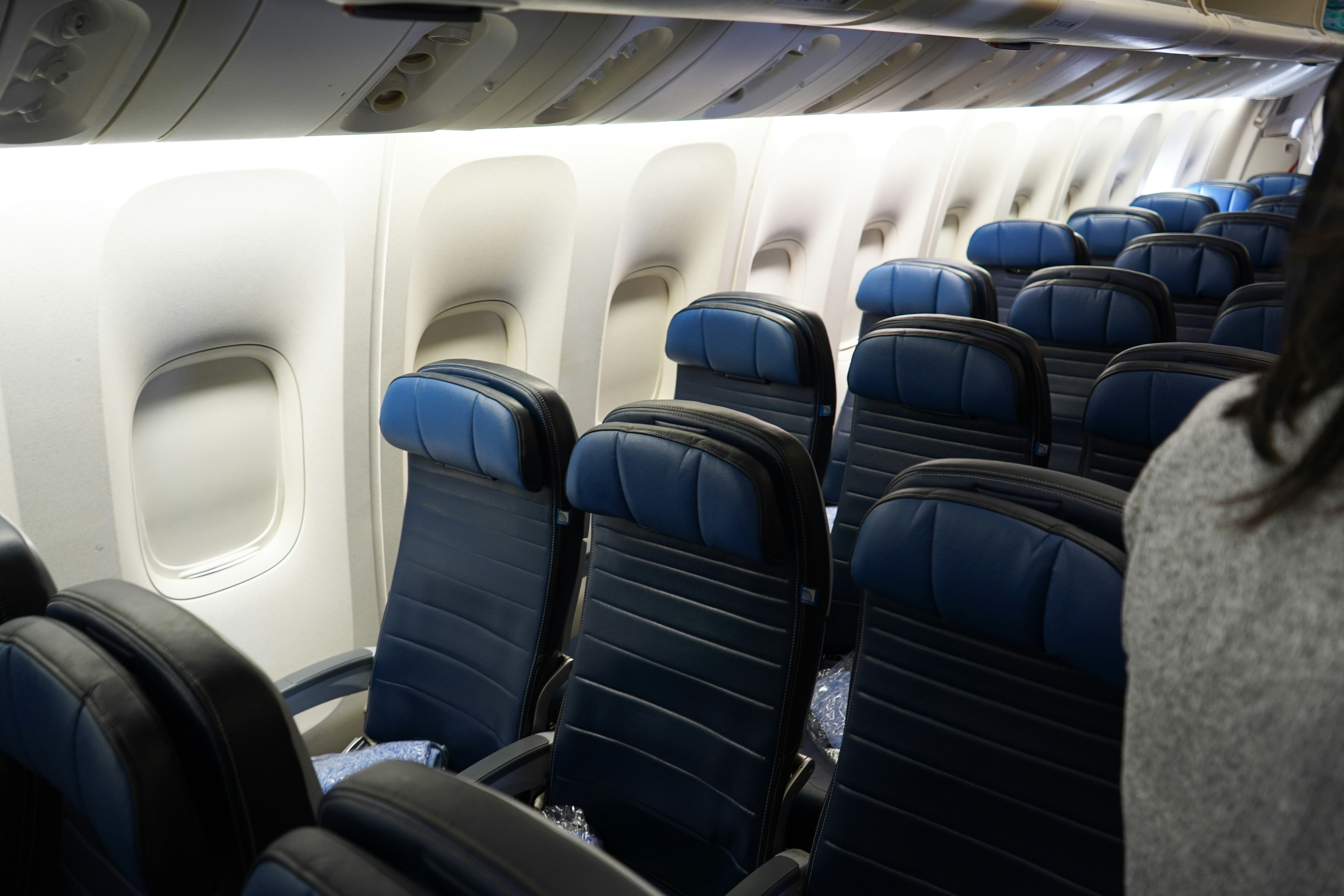 An Aisle of Quiet Rows: Blue Seats in a Narrow Cabin