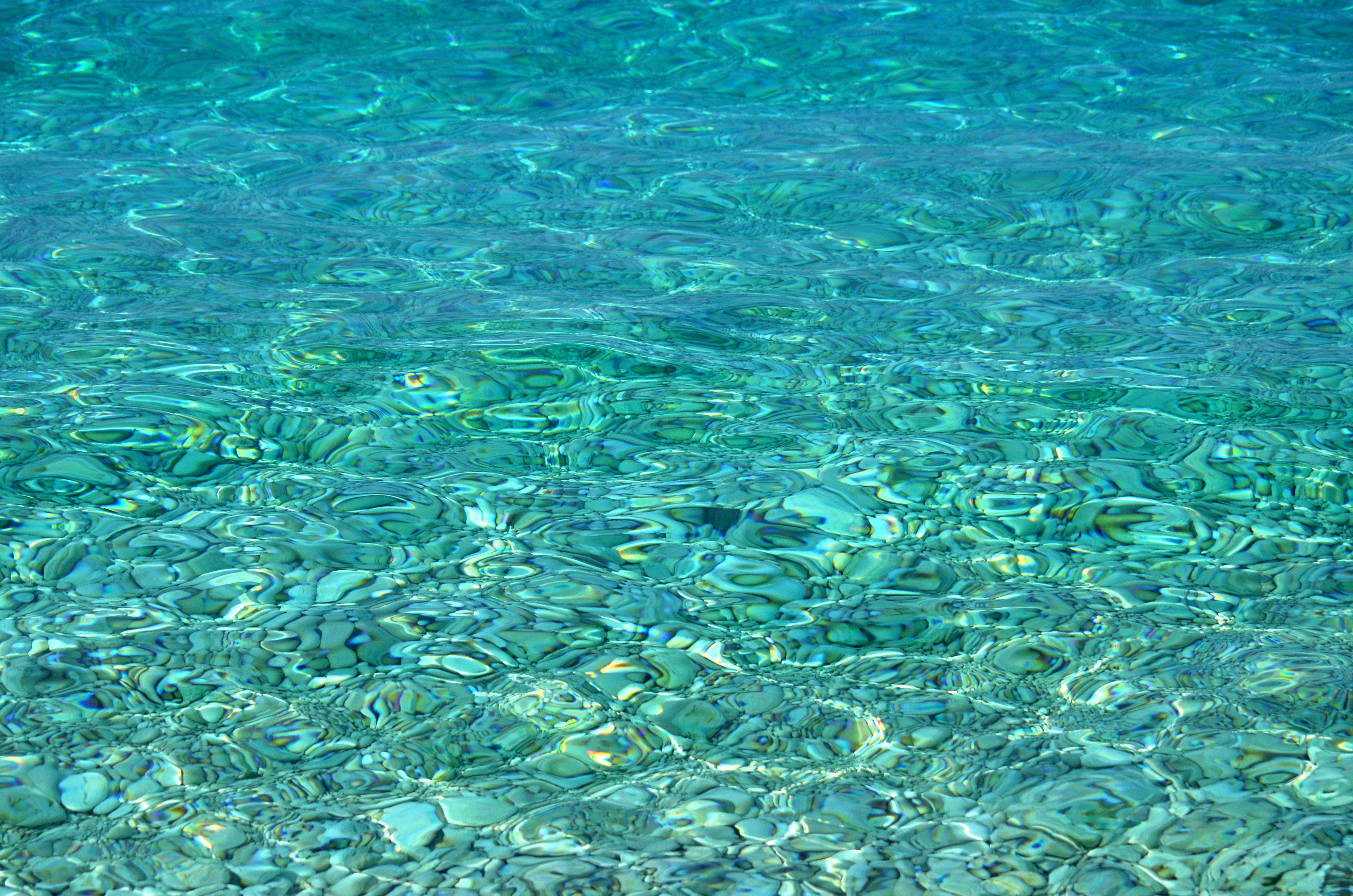 Sunlit Ripples: A Crystal Tide Over Pebbles