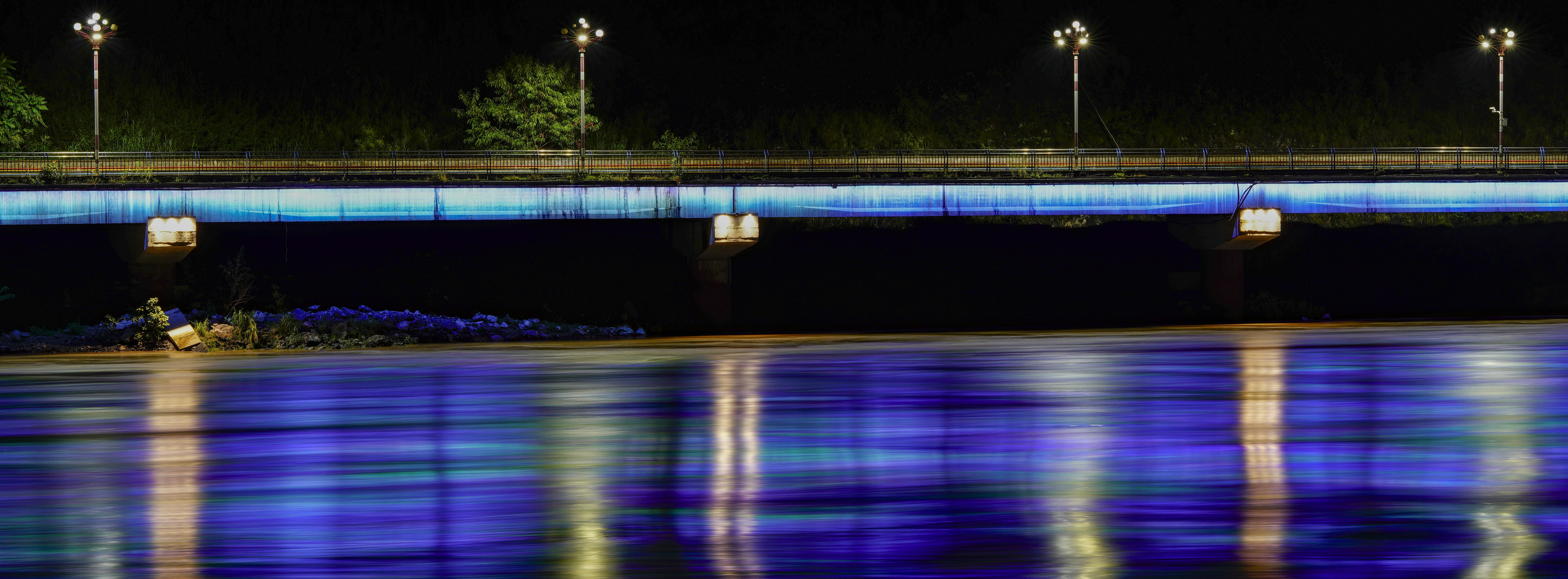 Night Ride: Reflections Beneath a Blue-Glowing Bridge