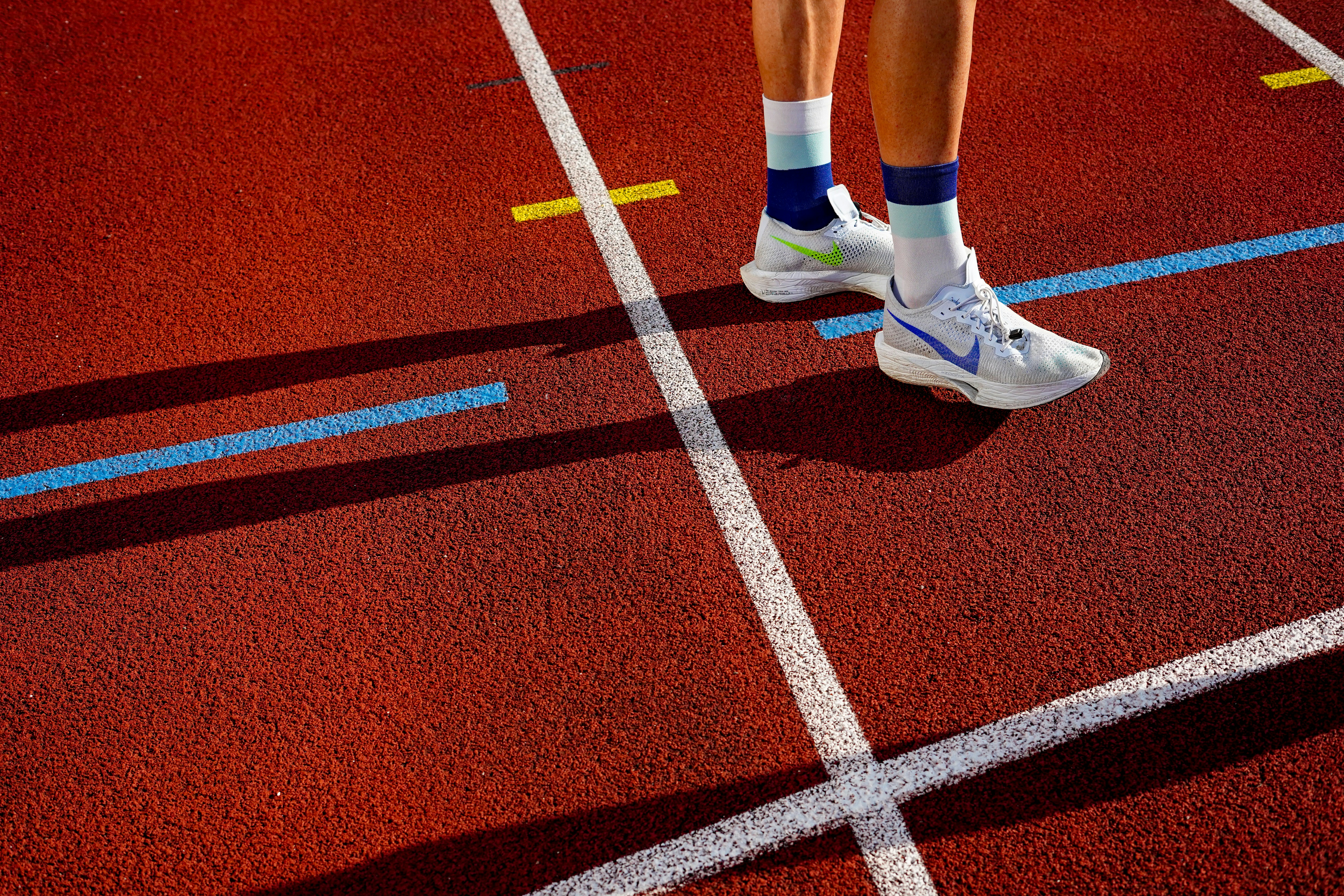 Crossing Lines: The Runner's Shadow on a Painted Track