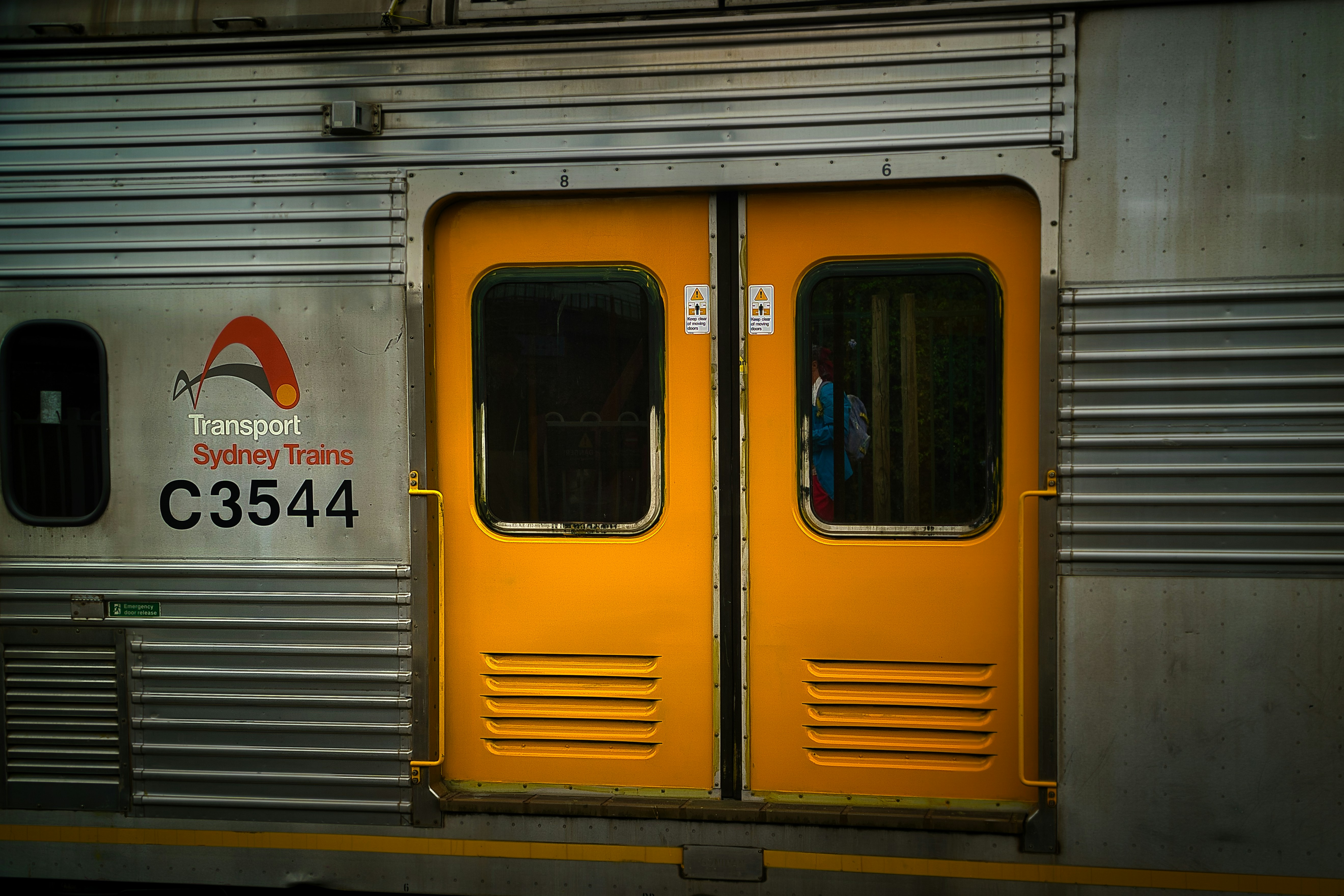 Bright Yellow Train Doors Framed by Silver Carriage on a Platform