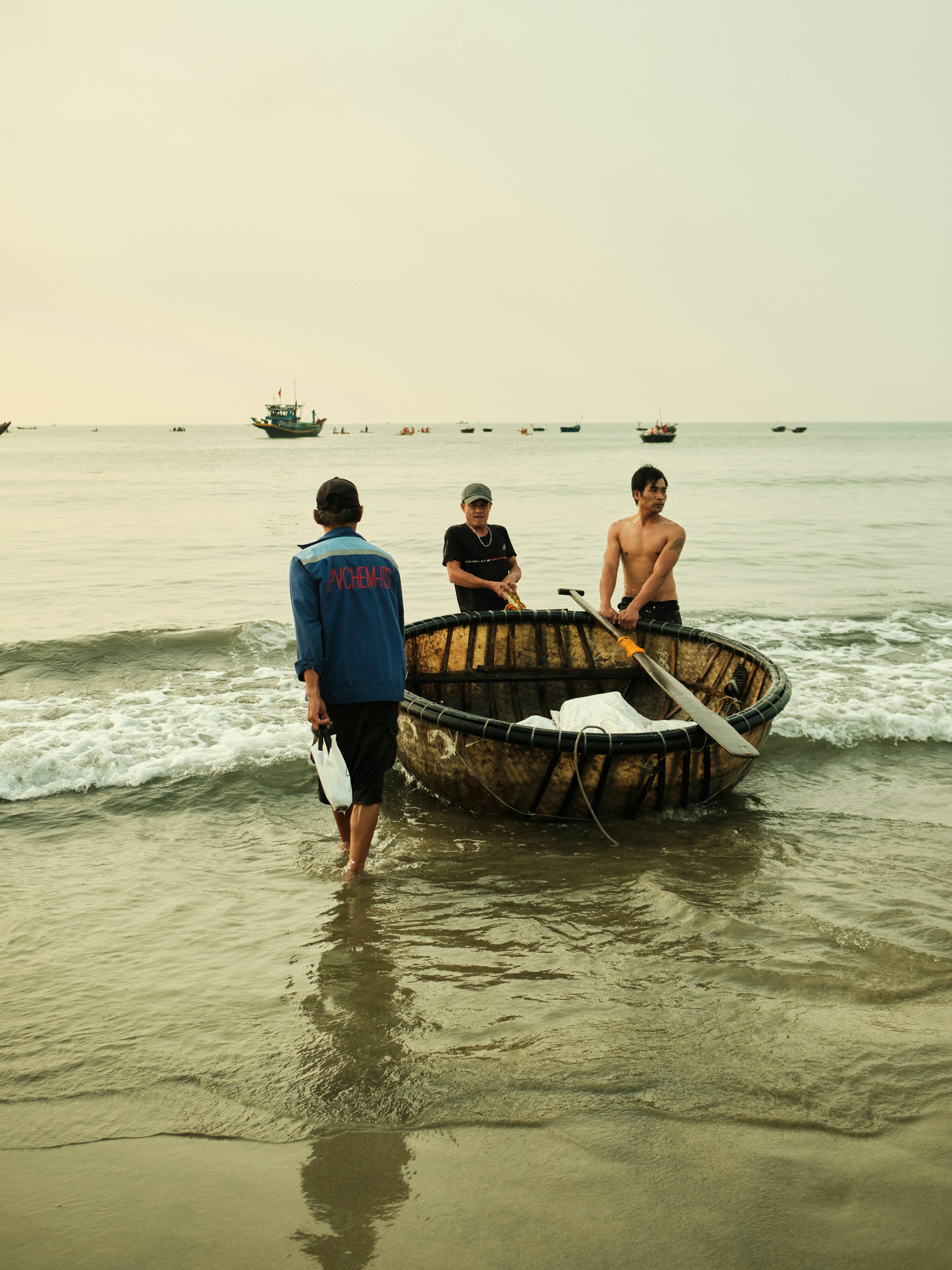 Boatmen at Dusk: A Row to Shore on a Quiet Vietnamese Beach