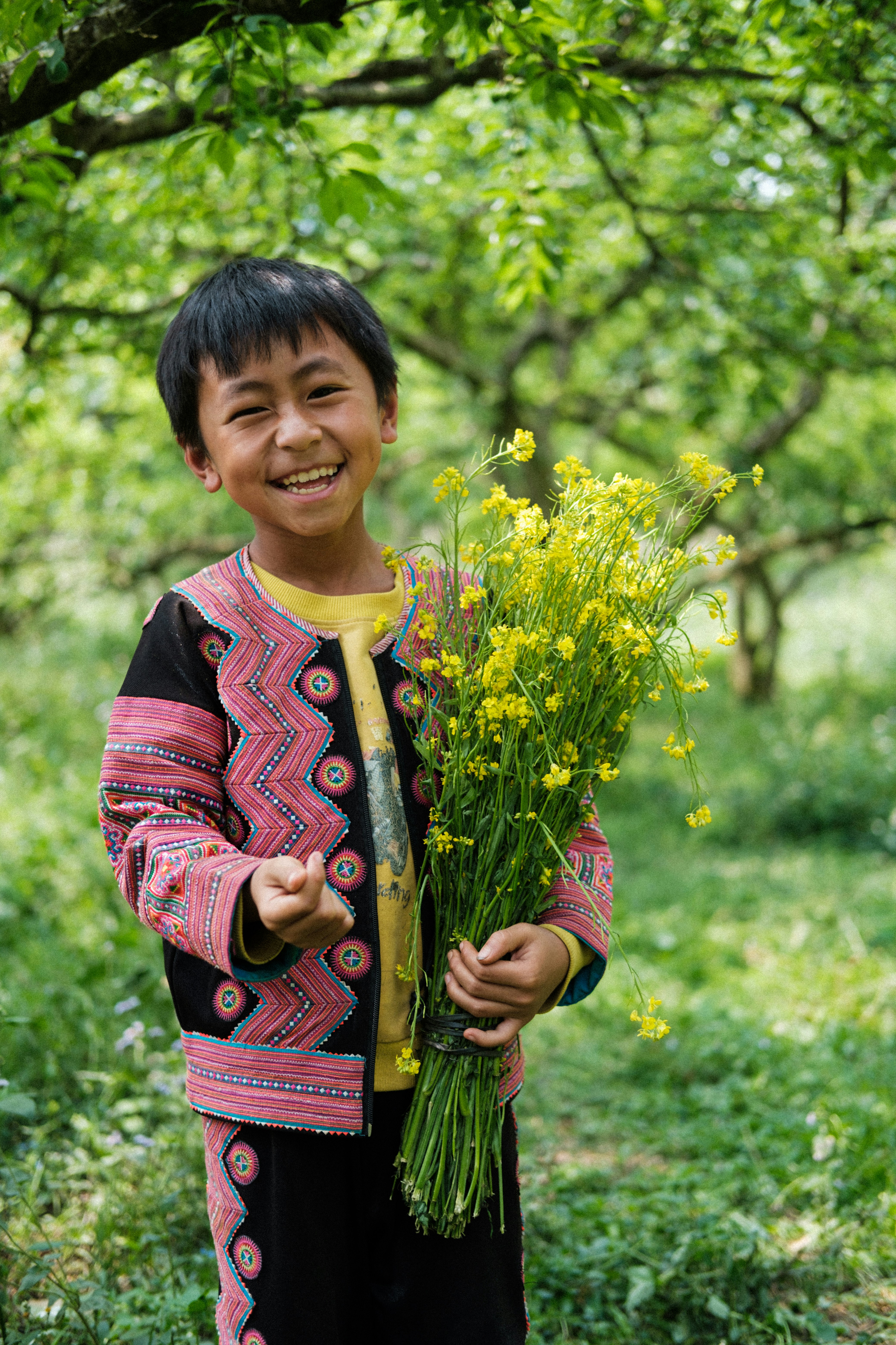 Smiling Harvest: A Child with a Bouquet of Wildflowers in a sunlit orchard