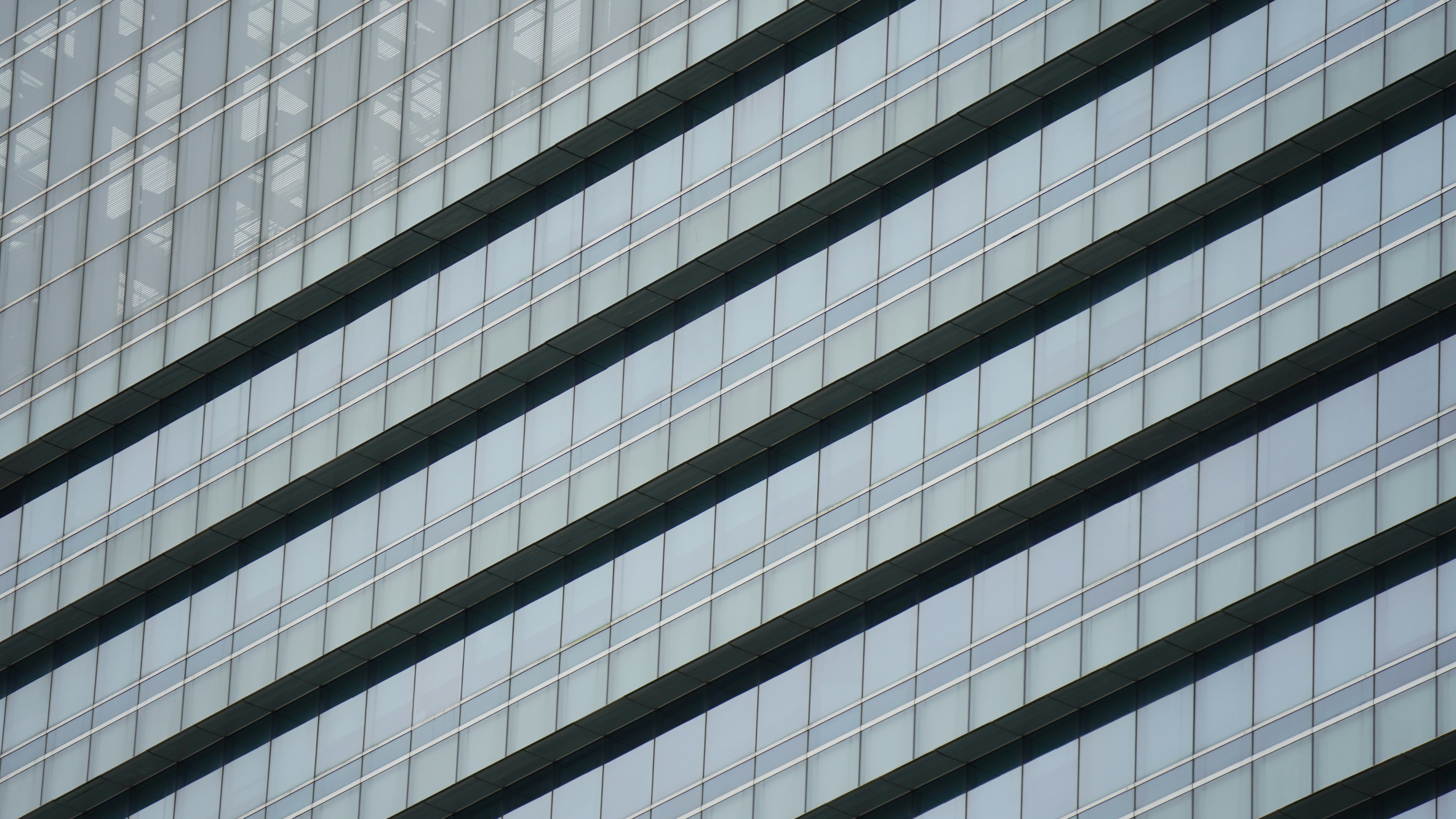 Diagonal Glass Strata: A Modern Office Facade in Time-Lrozen Light