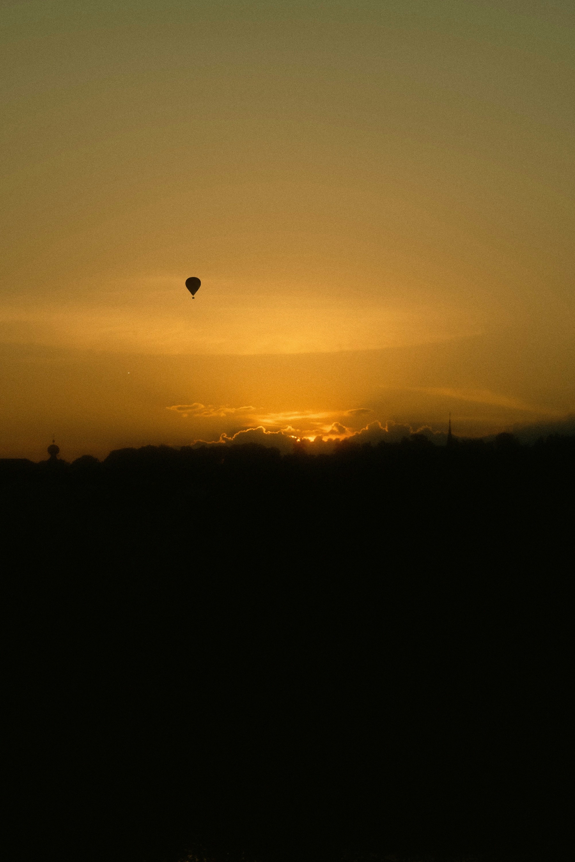 Sunset Ascend: A Lone Parachute Balloons over a Quiet Horizon