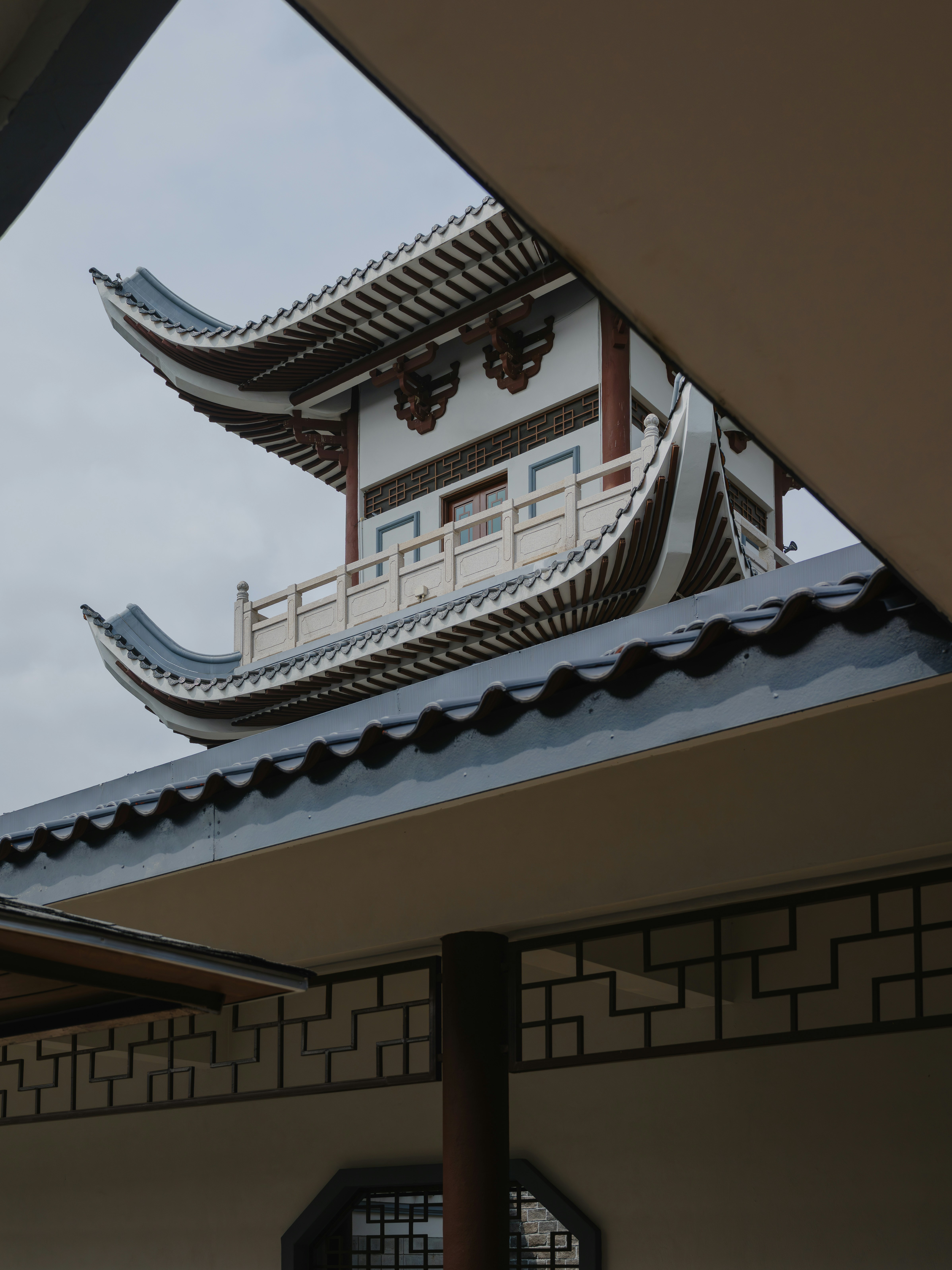 Layered Serenity: A Traditional Roof Tower Framed by Modern Angles
