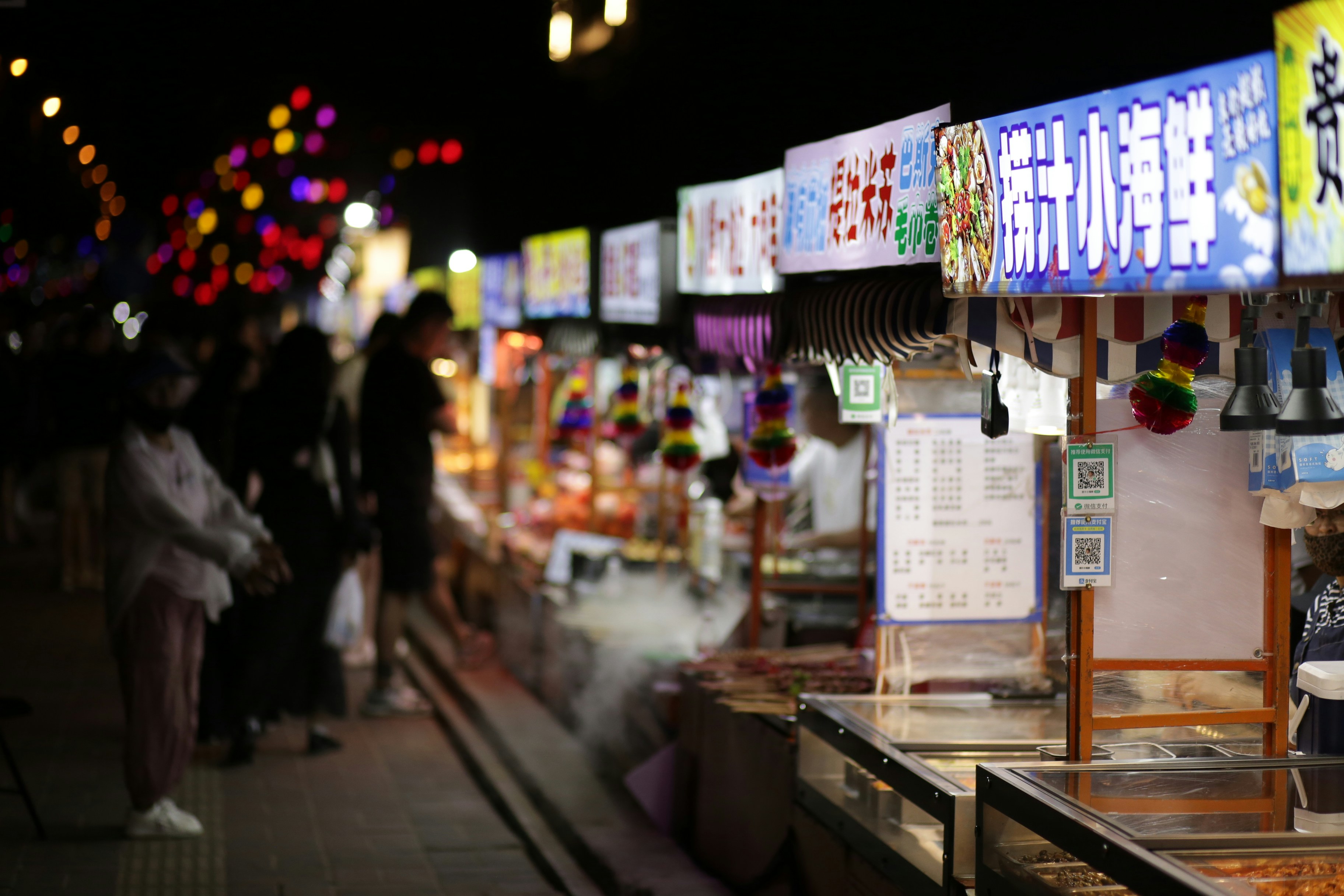Neon stalls and lingering steam in a quiet night market